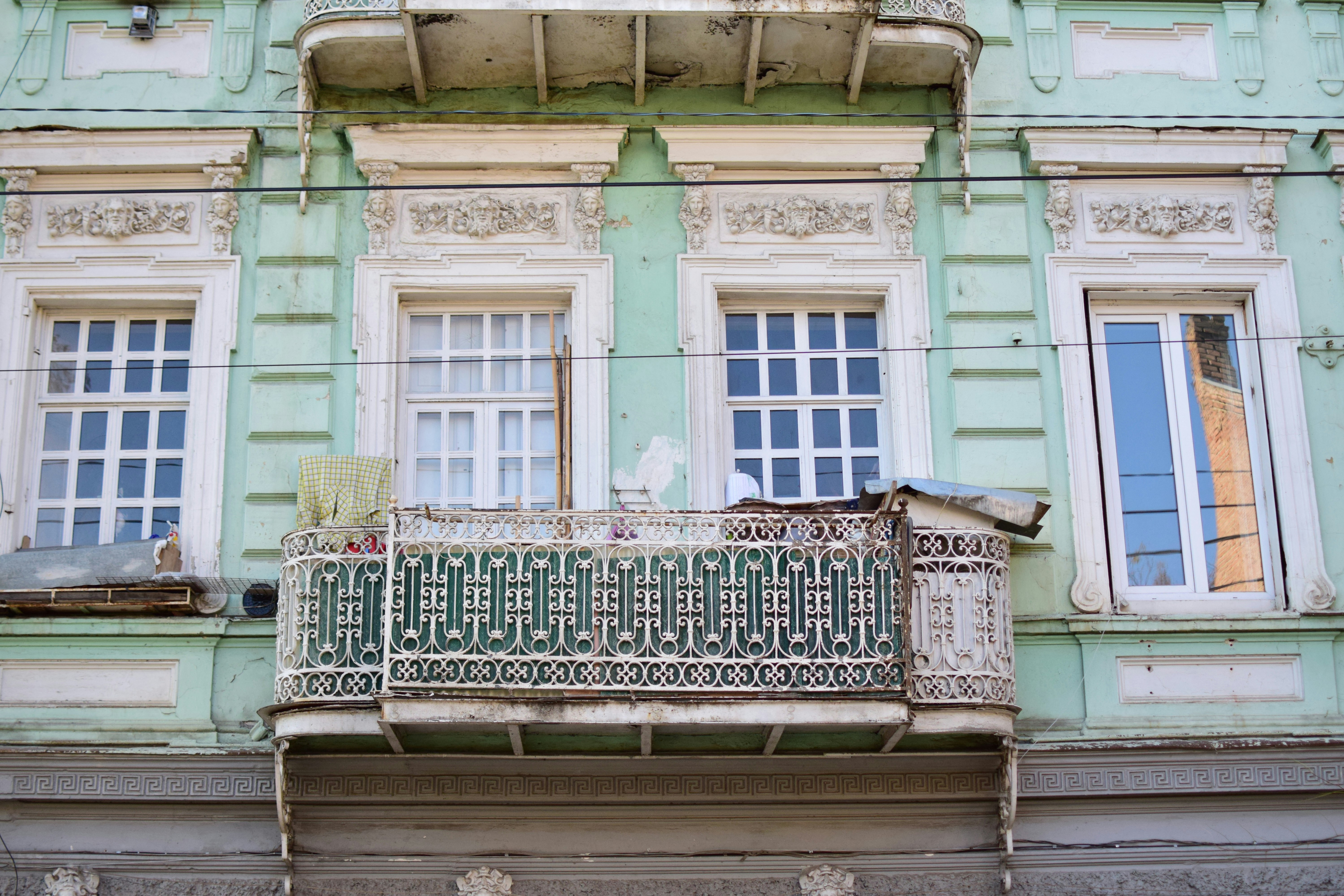 Timeworn Ironwork on a Mint-green Facade