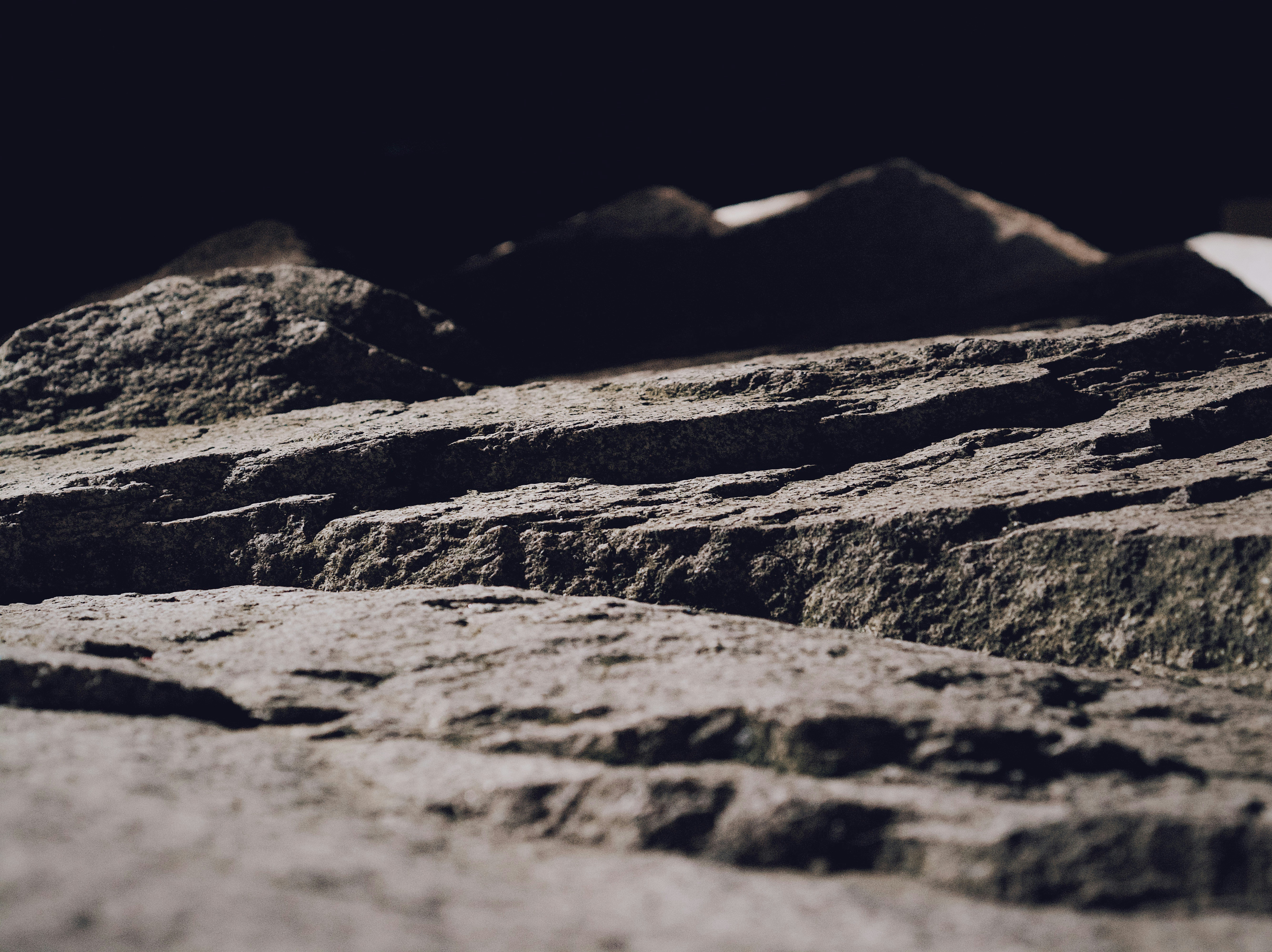 Close-up of textured rocks showcasing intricate layers and shadows, evoking a sense of ancient history and natural beauty.