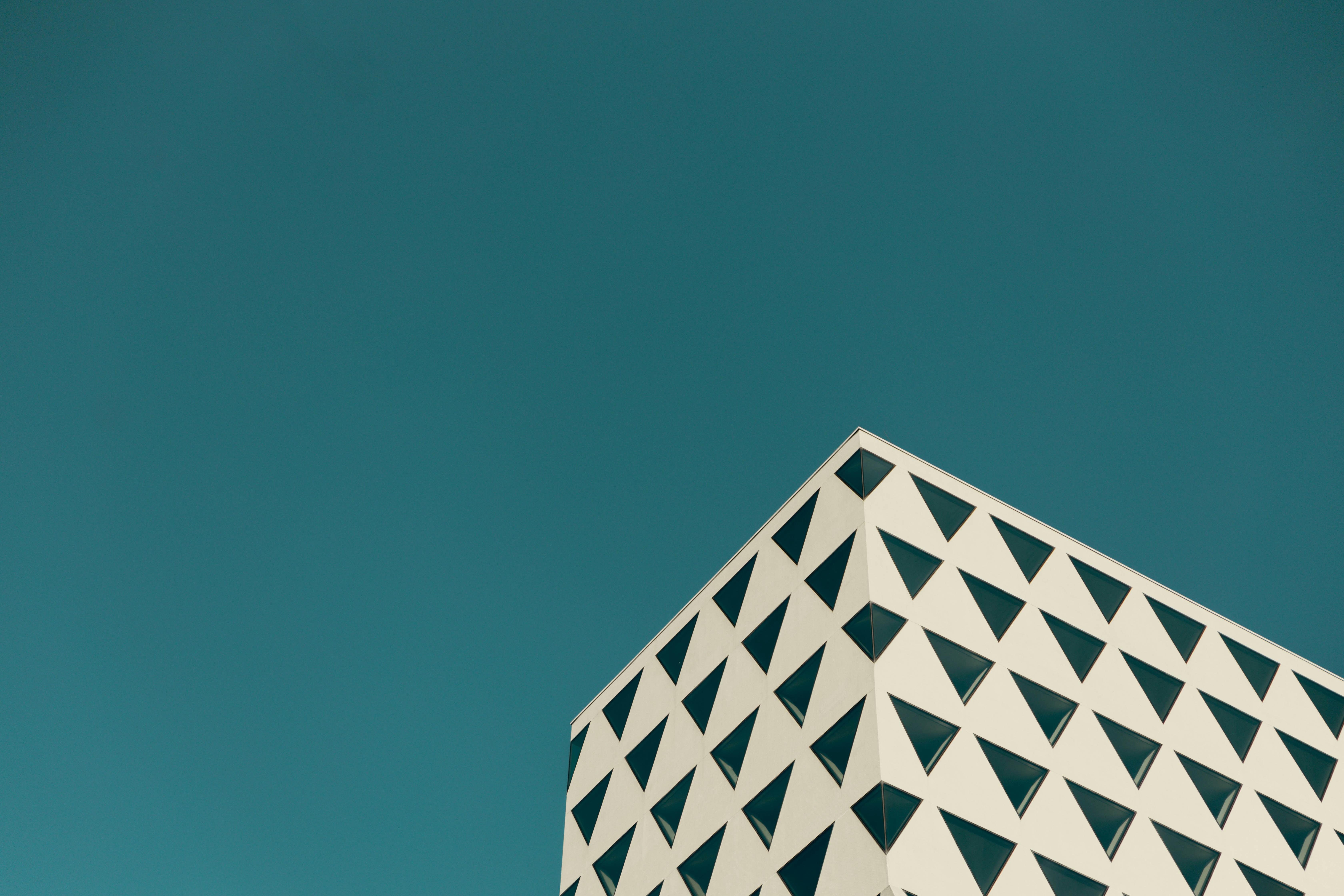 Modern building with triangular patterns set against a deep blue sky.
