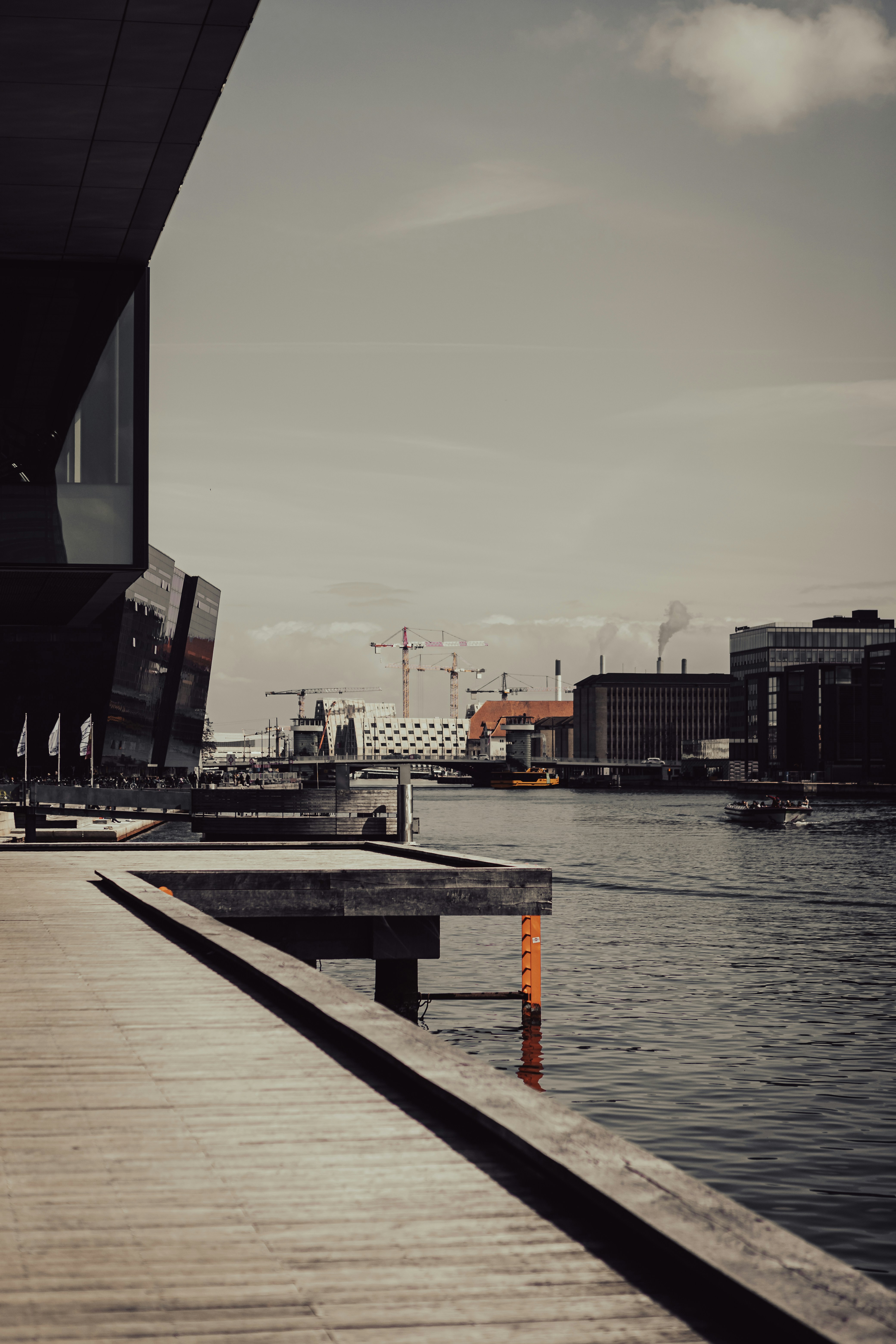 a dock with a boat in the water by buildings