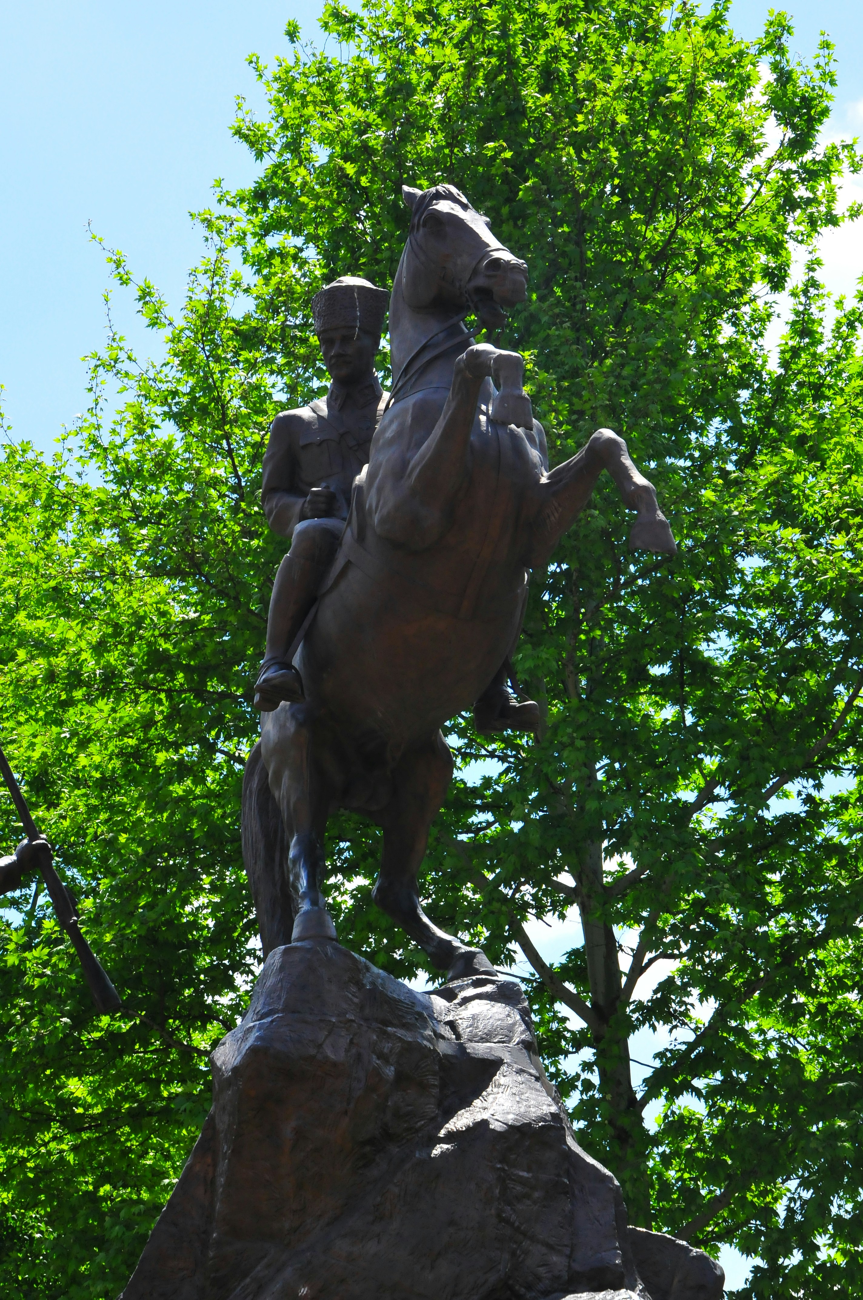 Rearing Bronze: An Equestrian Monument Framed by Lush Greenery