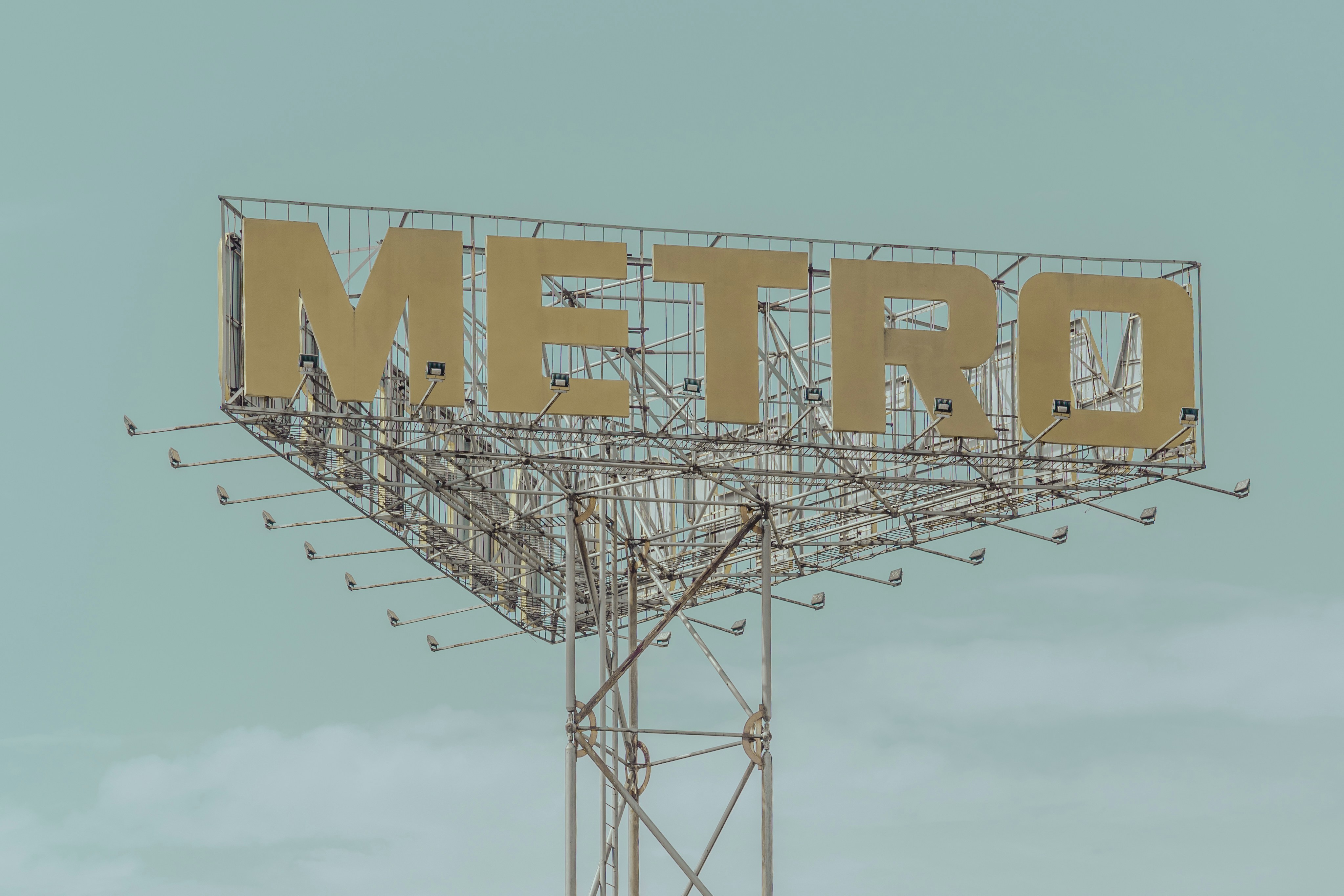 METRO on a Steel Spine: Skyward Signage in a Pale Turquoise Sky