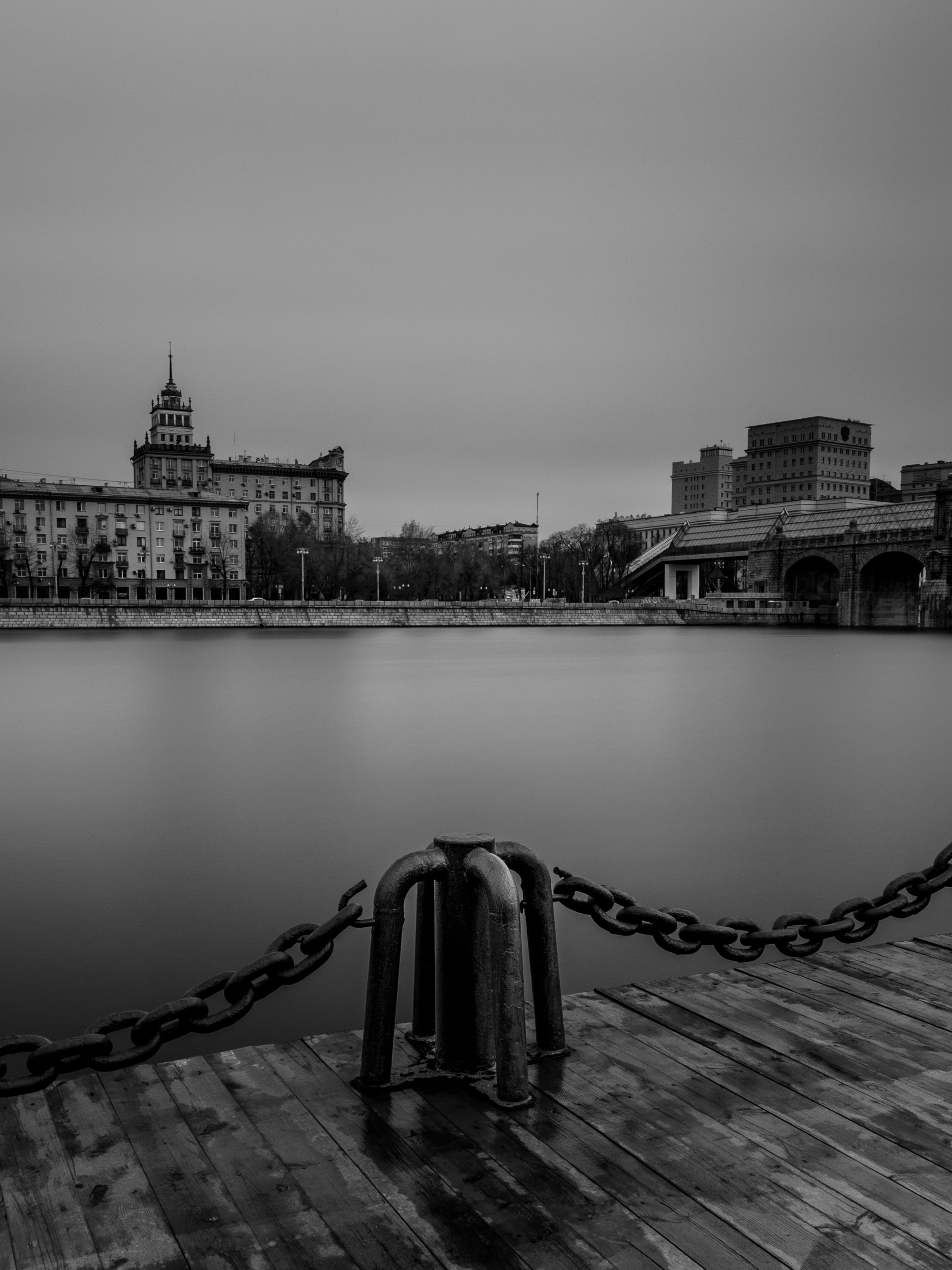 Anchor in the Monochrome: Chains Framing a Quiet Riverside CityscapeLKHTK