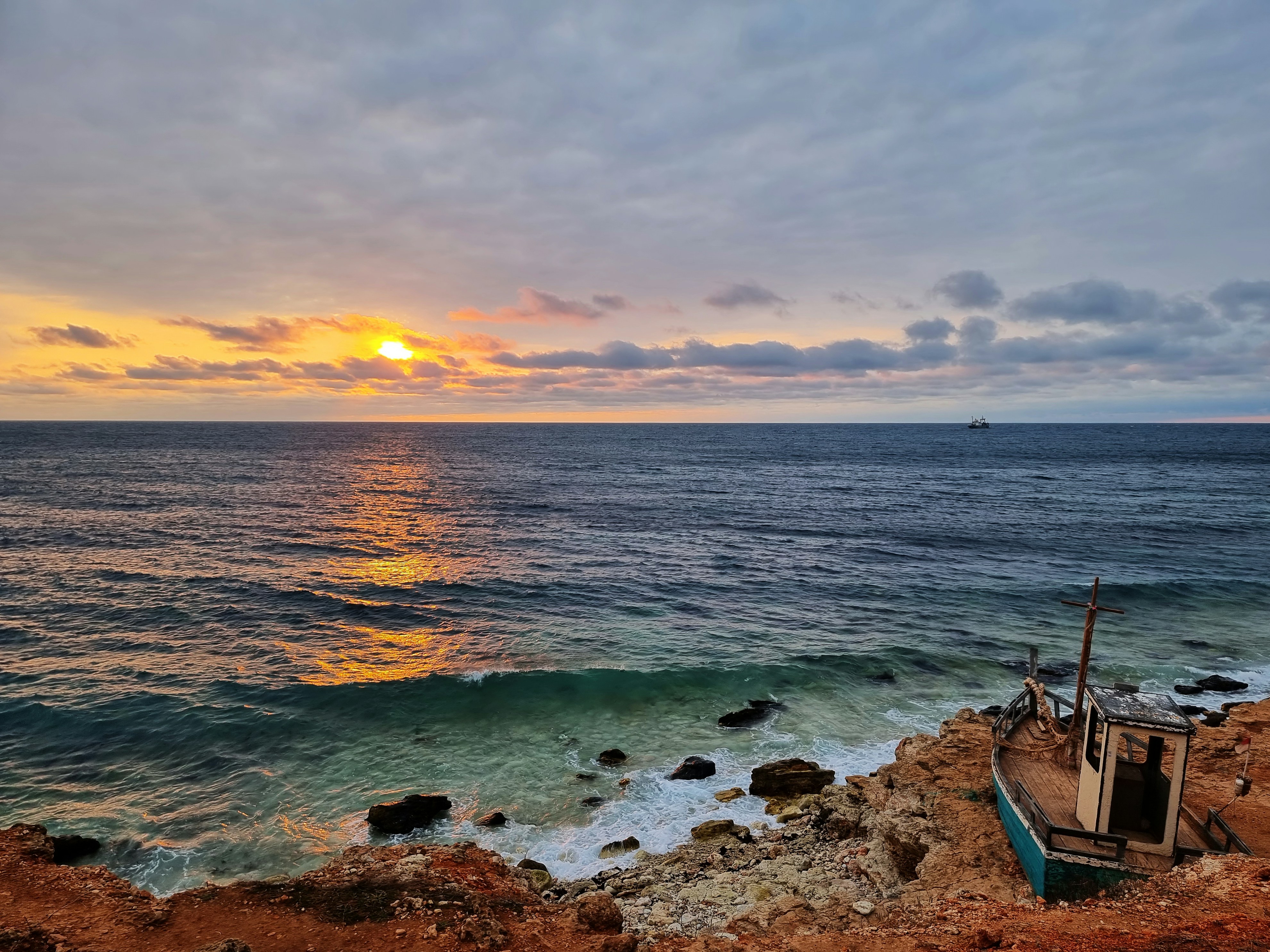 Sunlit Horizon Over Turquoise Shore with Rustic Boat
