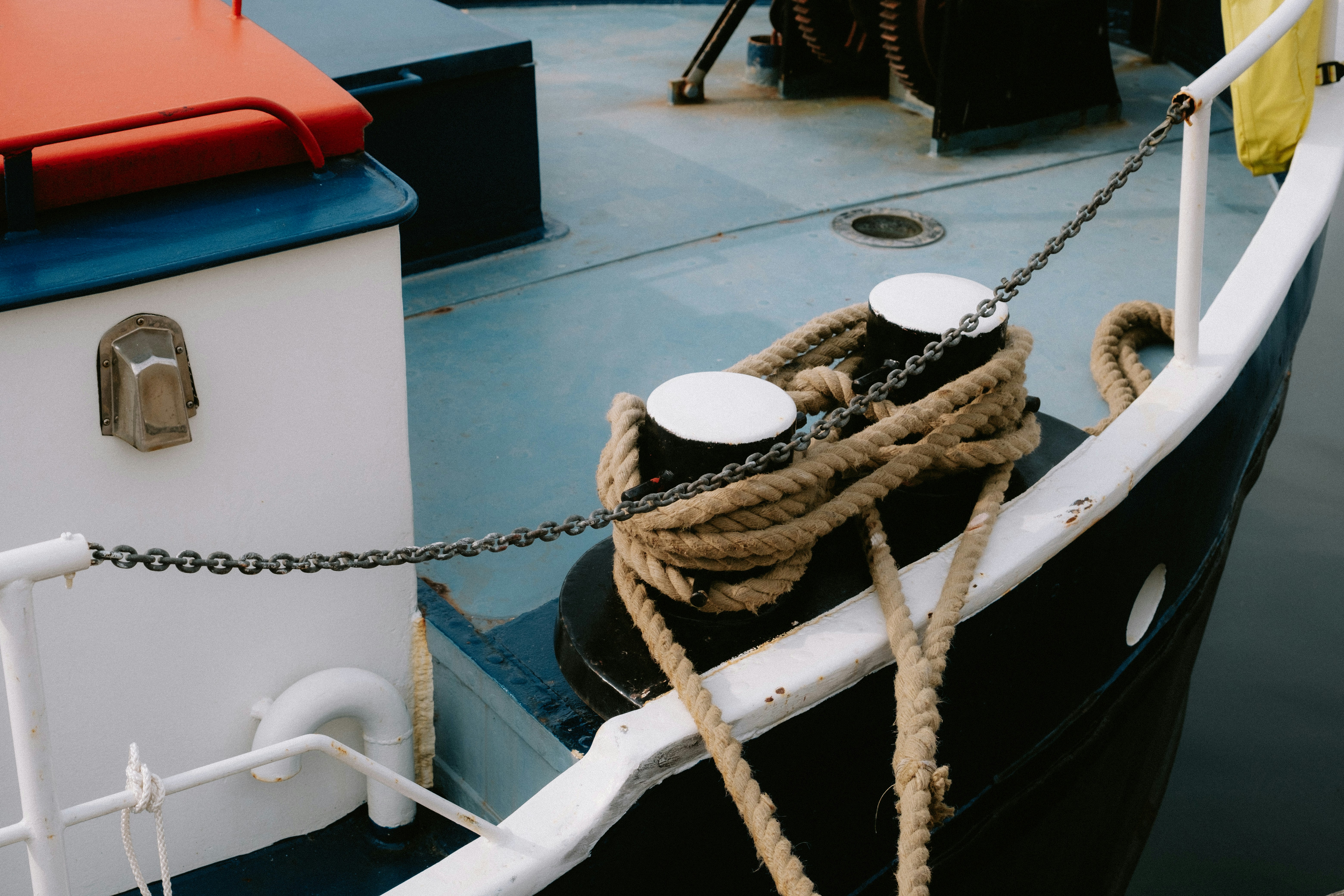 Coiled ropes and mooring cleats on a boat deck, showcasing maritime details and textures.