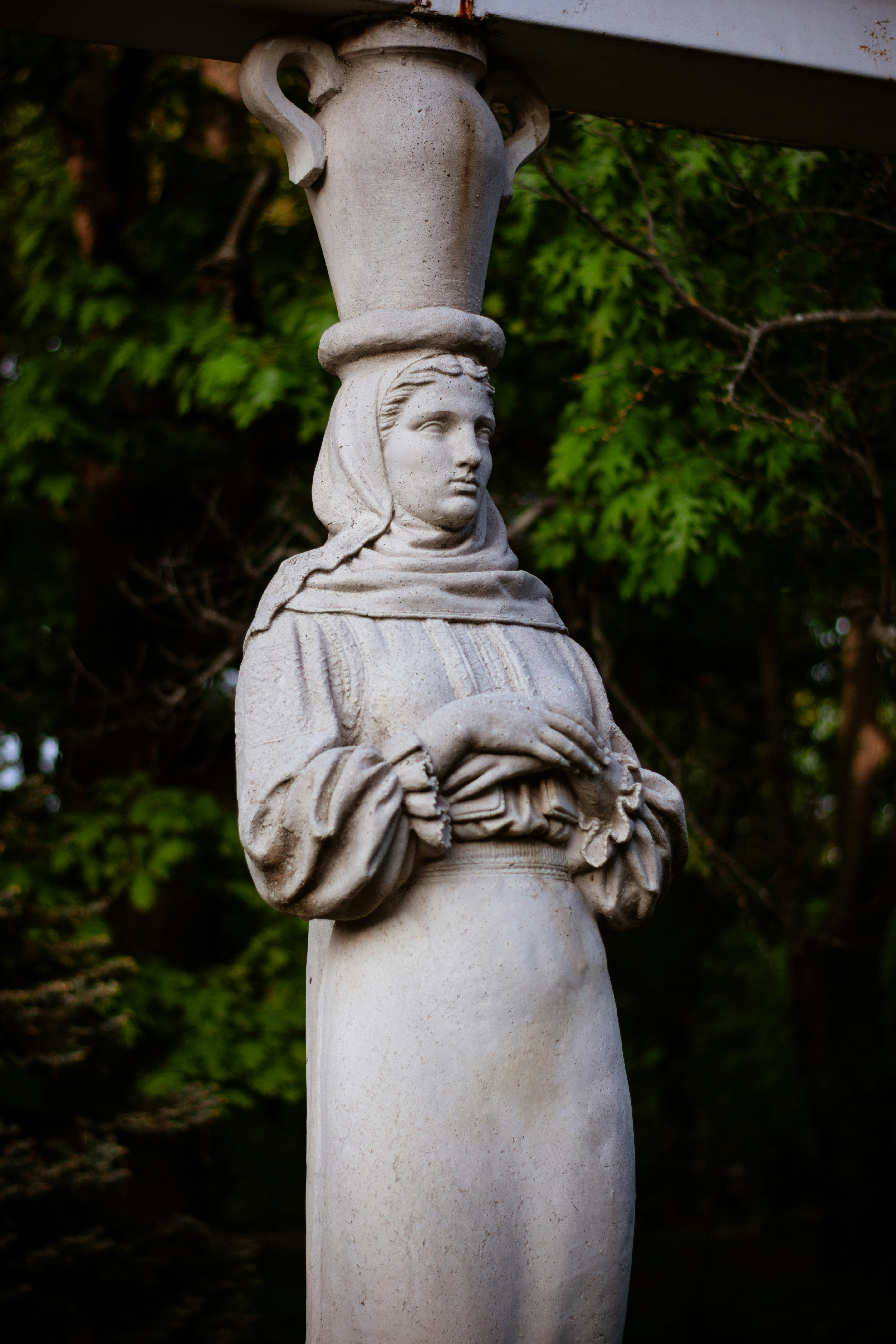 Hooded Marble Figure Under a Garden Canopy