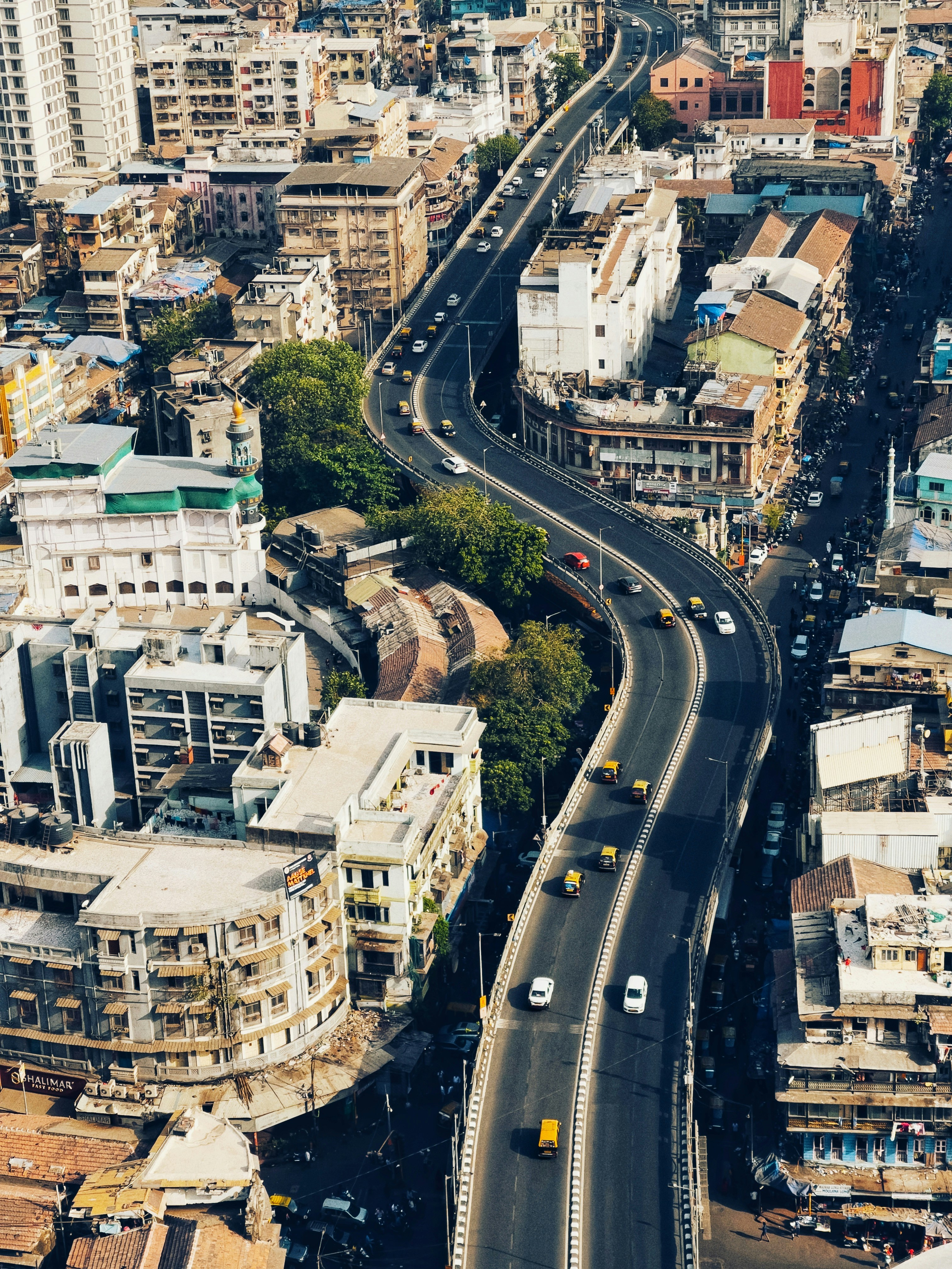 Coiled City Ribbon: Aerial Arc of Traffic Through Dense Urban Core