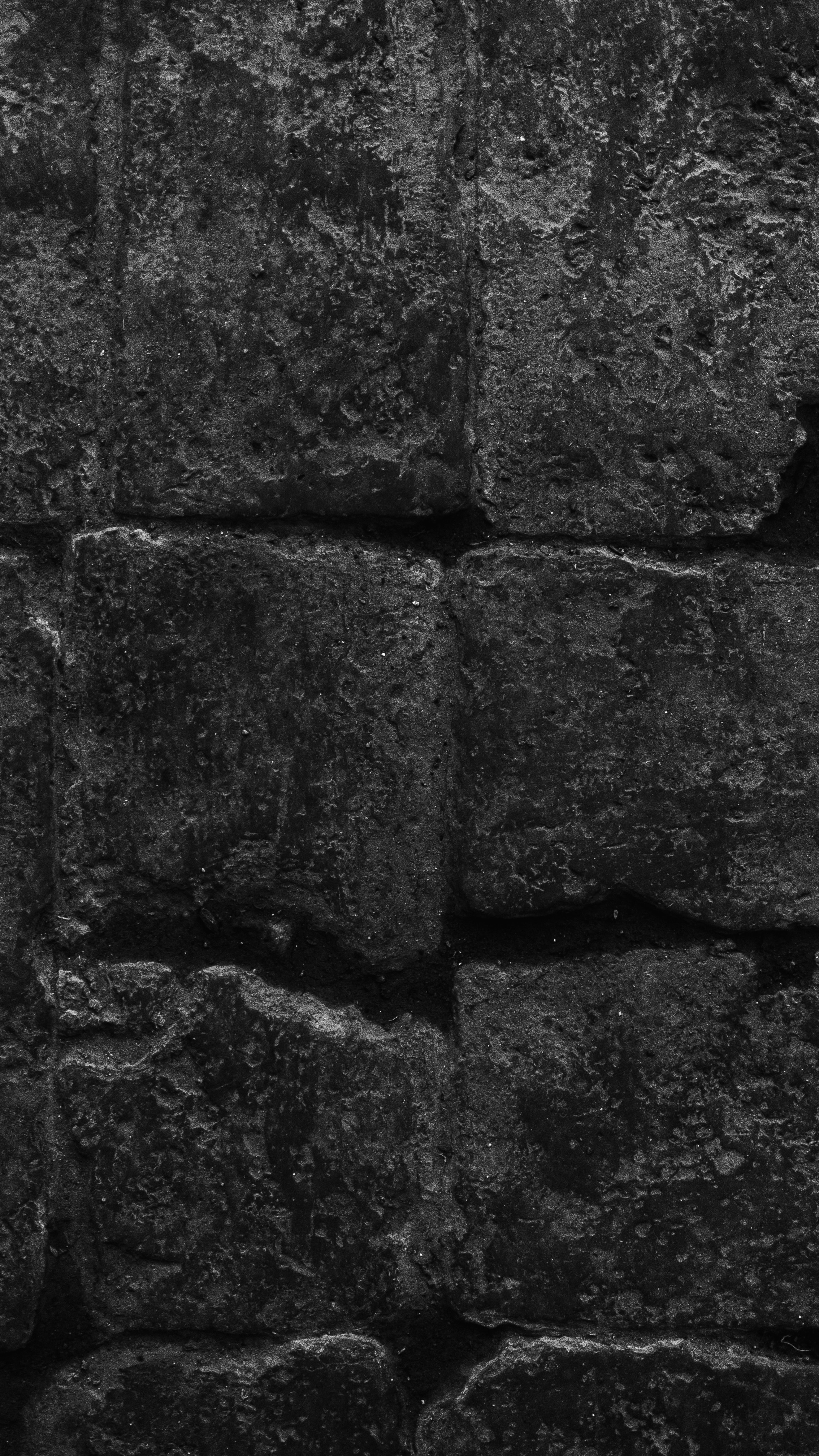 Close-up of a weathered stone wall showcasing intricate textures and shadows.