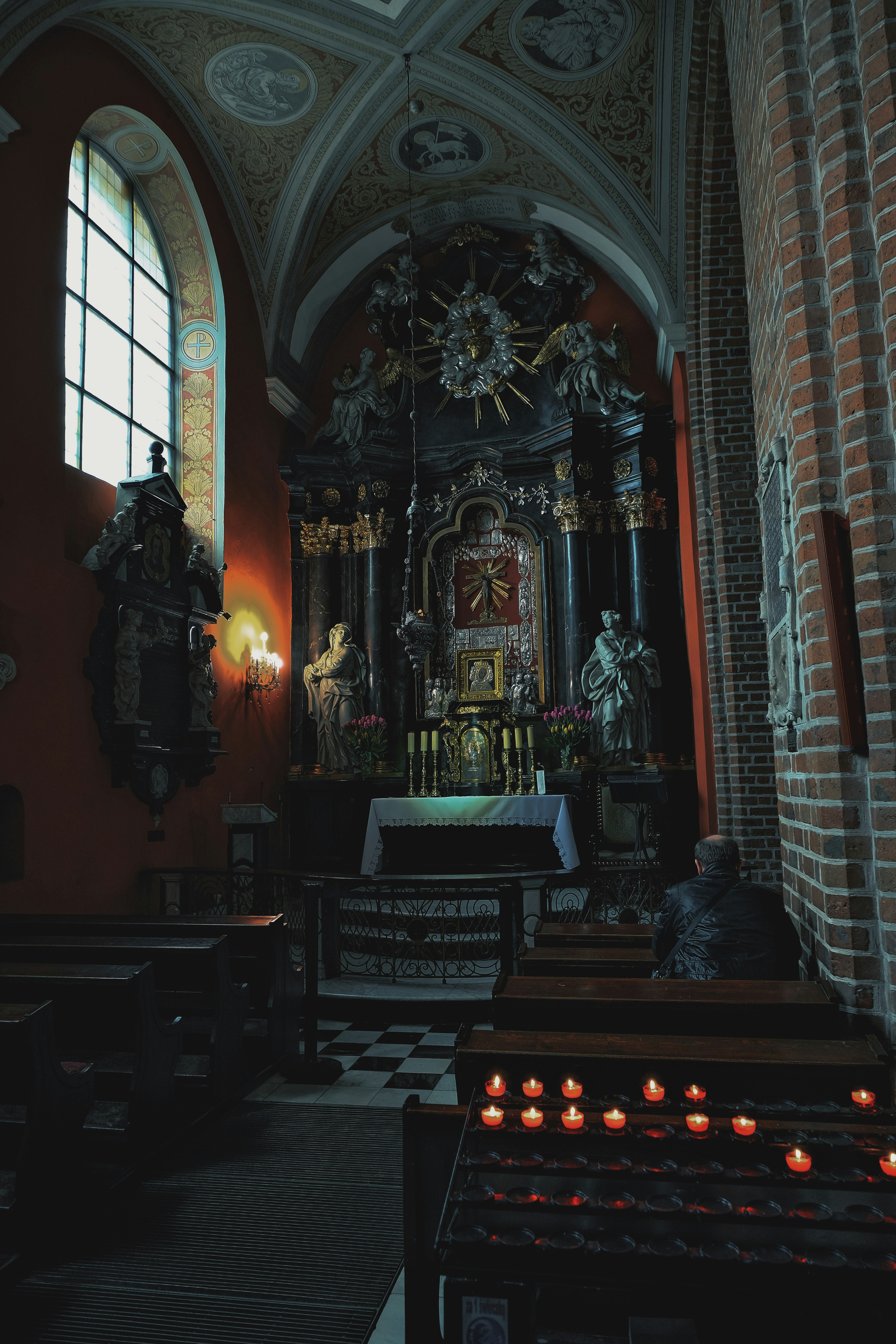 Intricate altar adorned with statues and candles in a dimly lit chapel, inviting reflection and reverence.