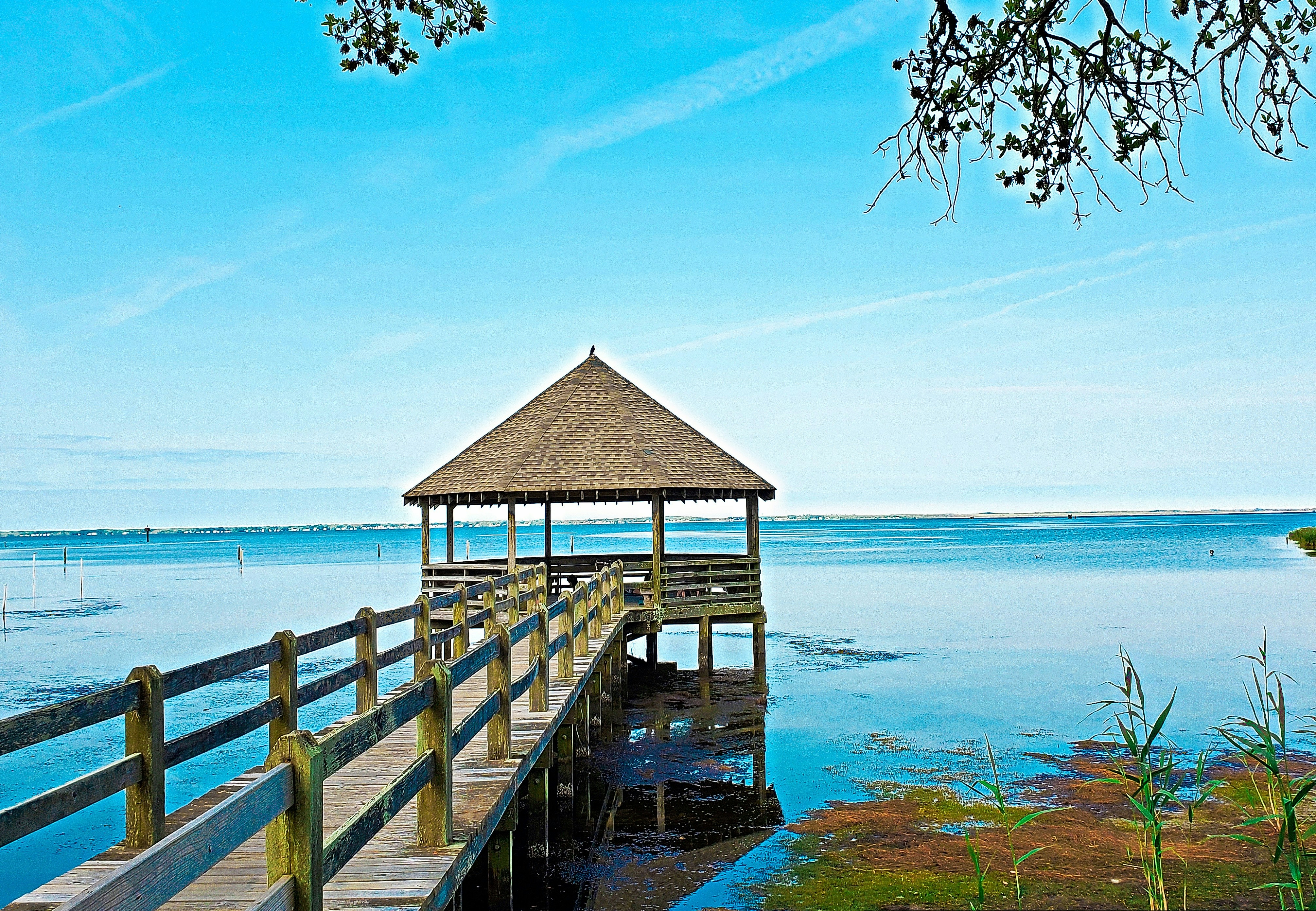 A wooden dock leading to a small shack on a beach photo – Free Pier ...