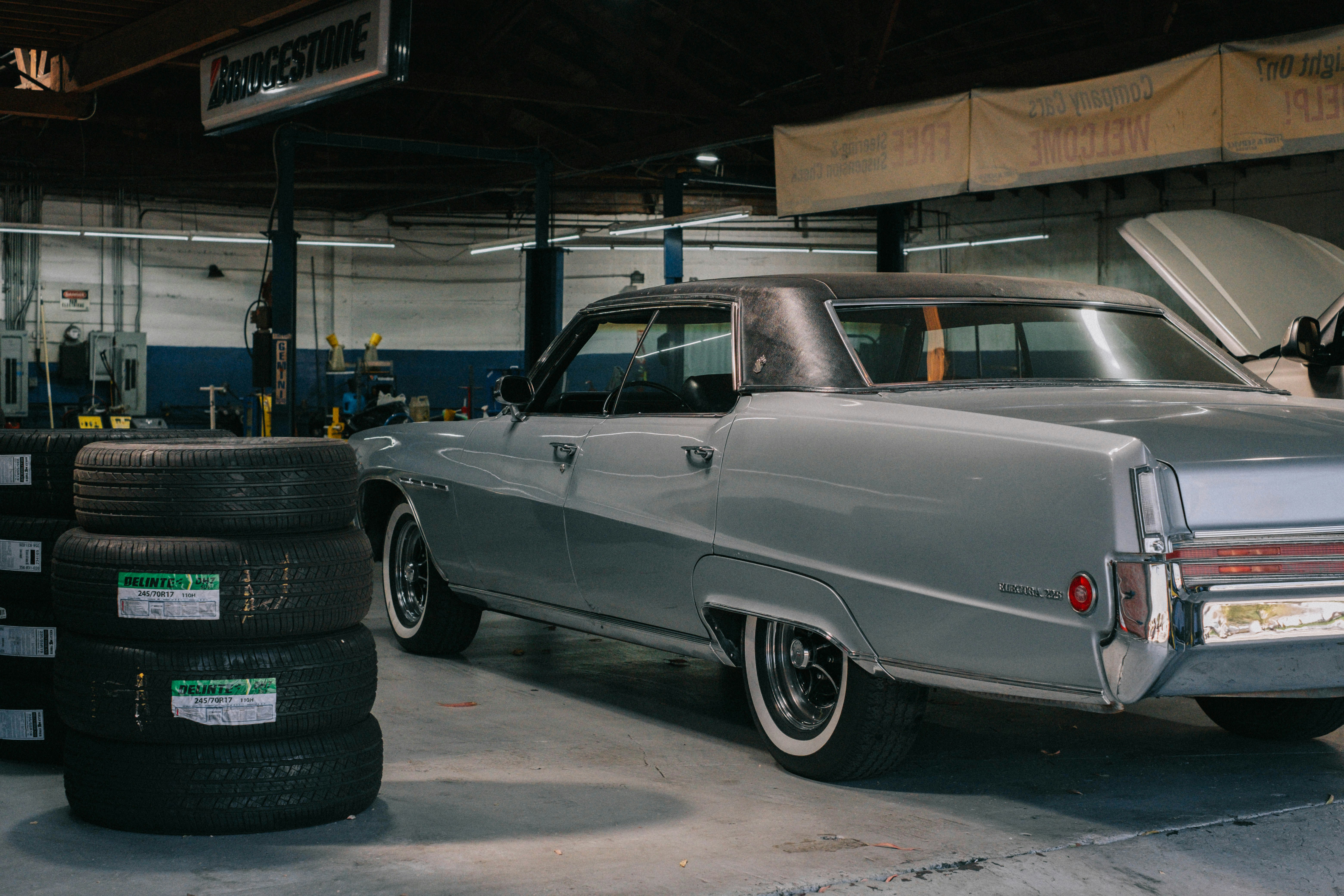 A car with a large stack of tires in a garage photo – Free Grey Image ...