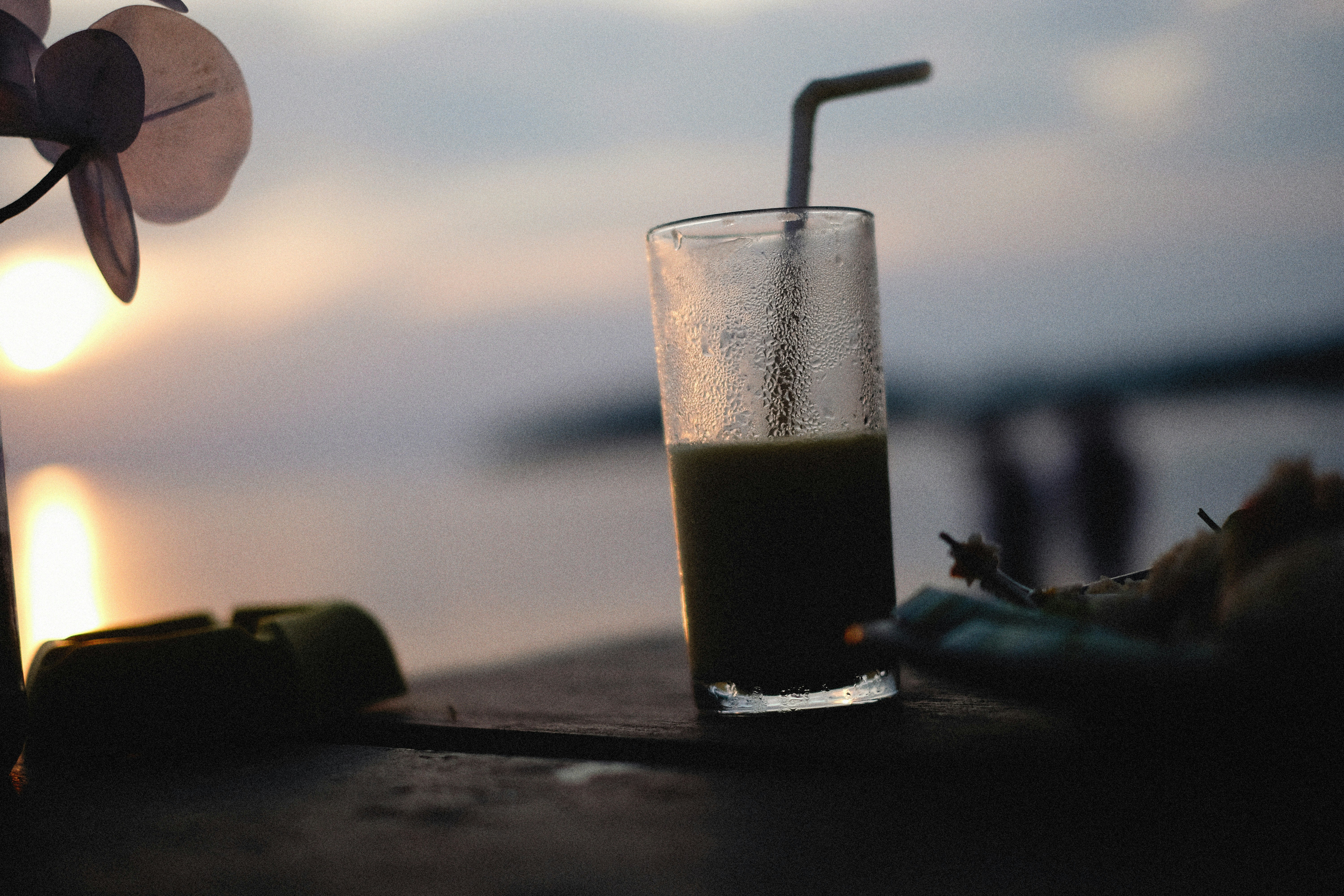 Sunset on the Deck: A Frosted Glass with Straw and Soft Horizon