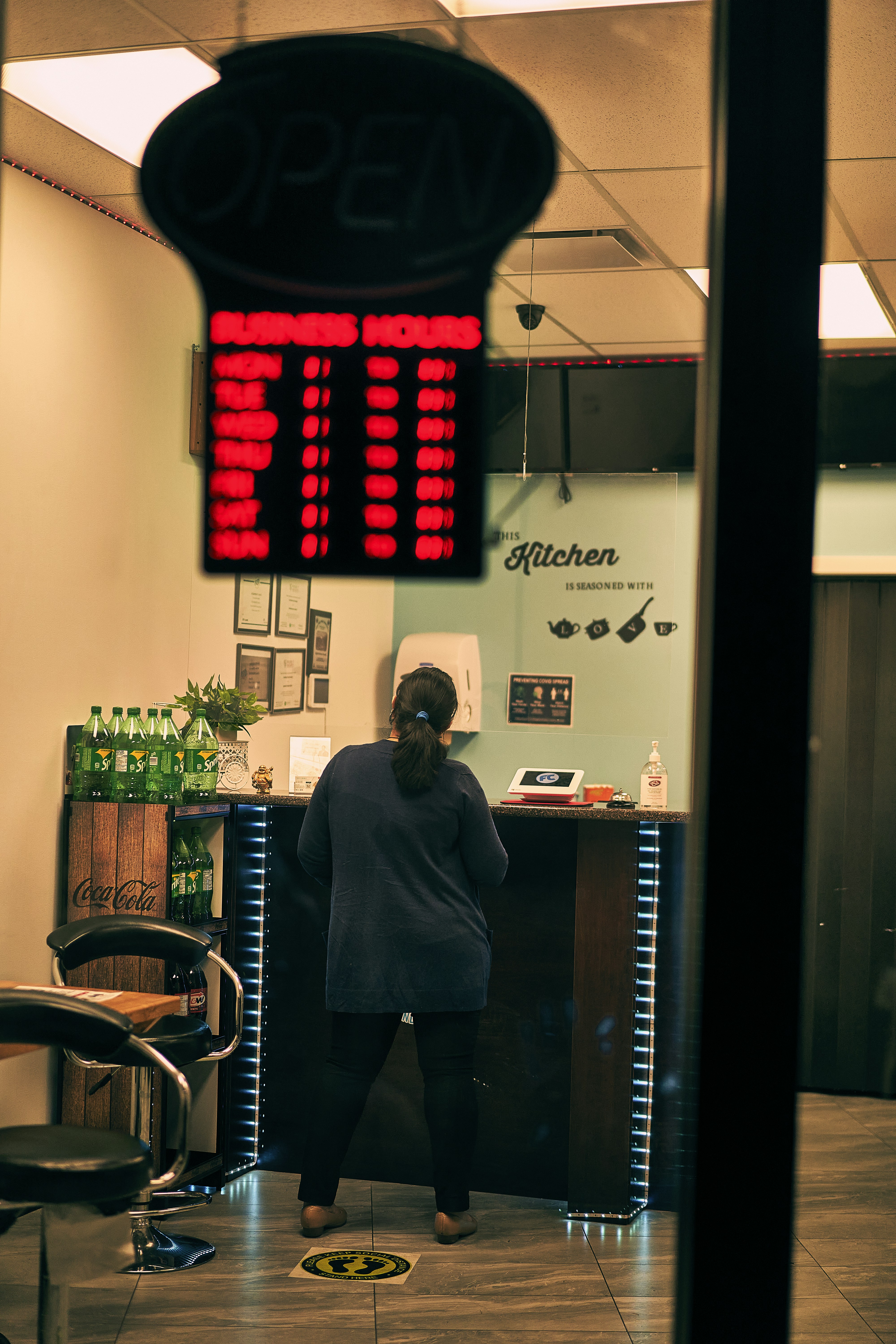 a person standing in front of a counter with a sign on it