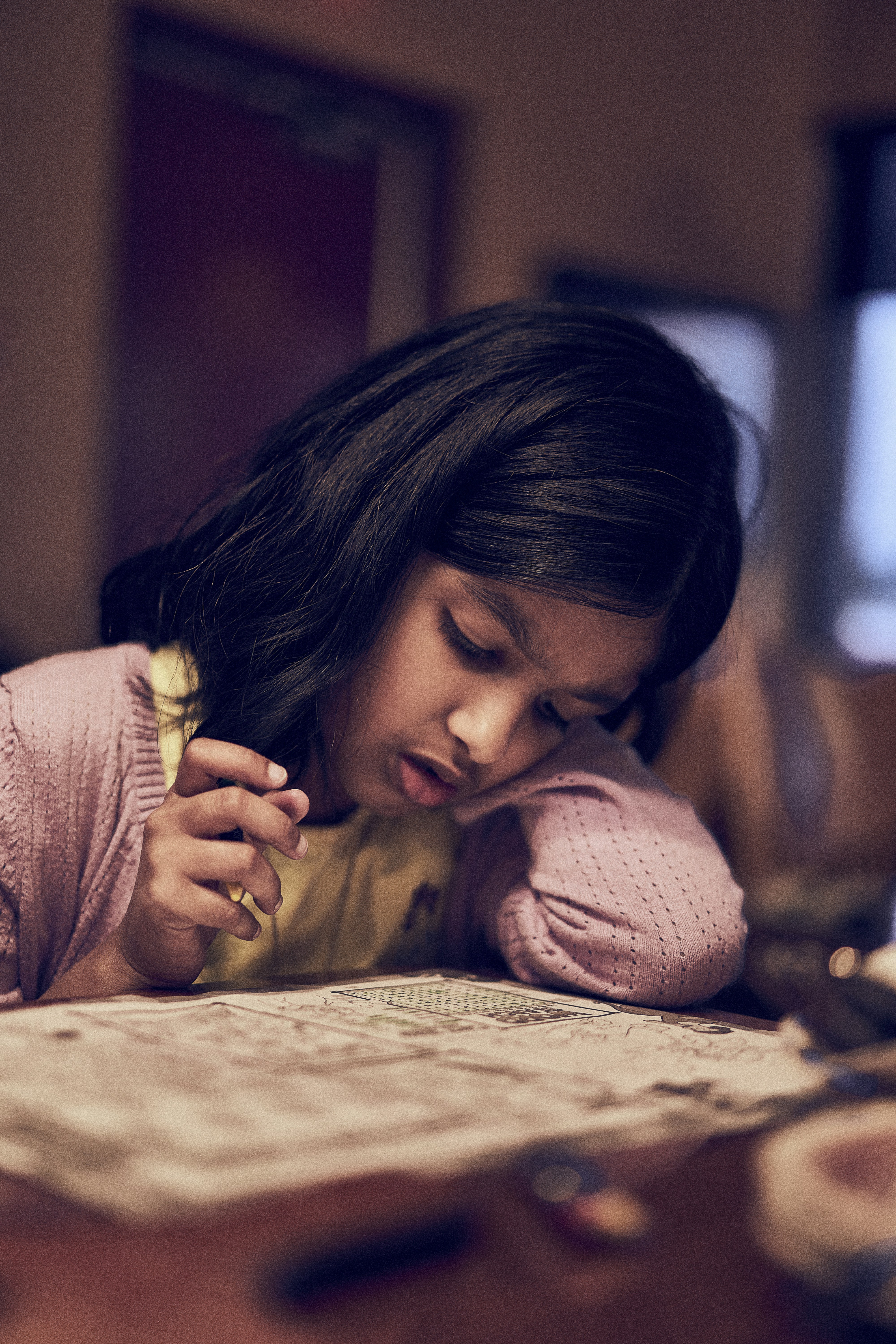 Amber Quiet: a girl reads a newspaper under warm indoor light