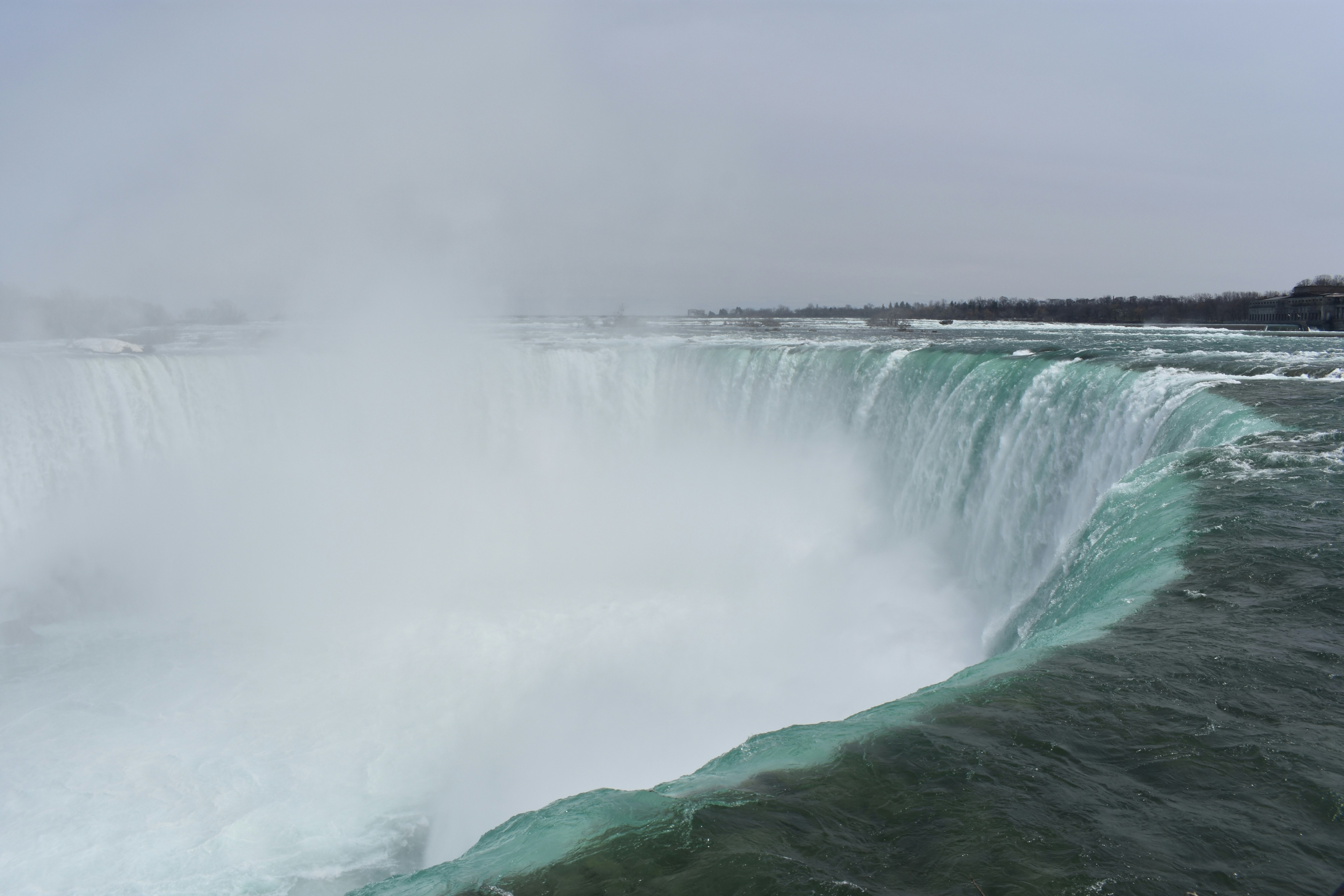 Powerful waterfall cascading into a misty abyss, surrounded by a serene landscape. The scene captures the raw energy of nature.