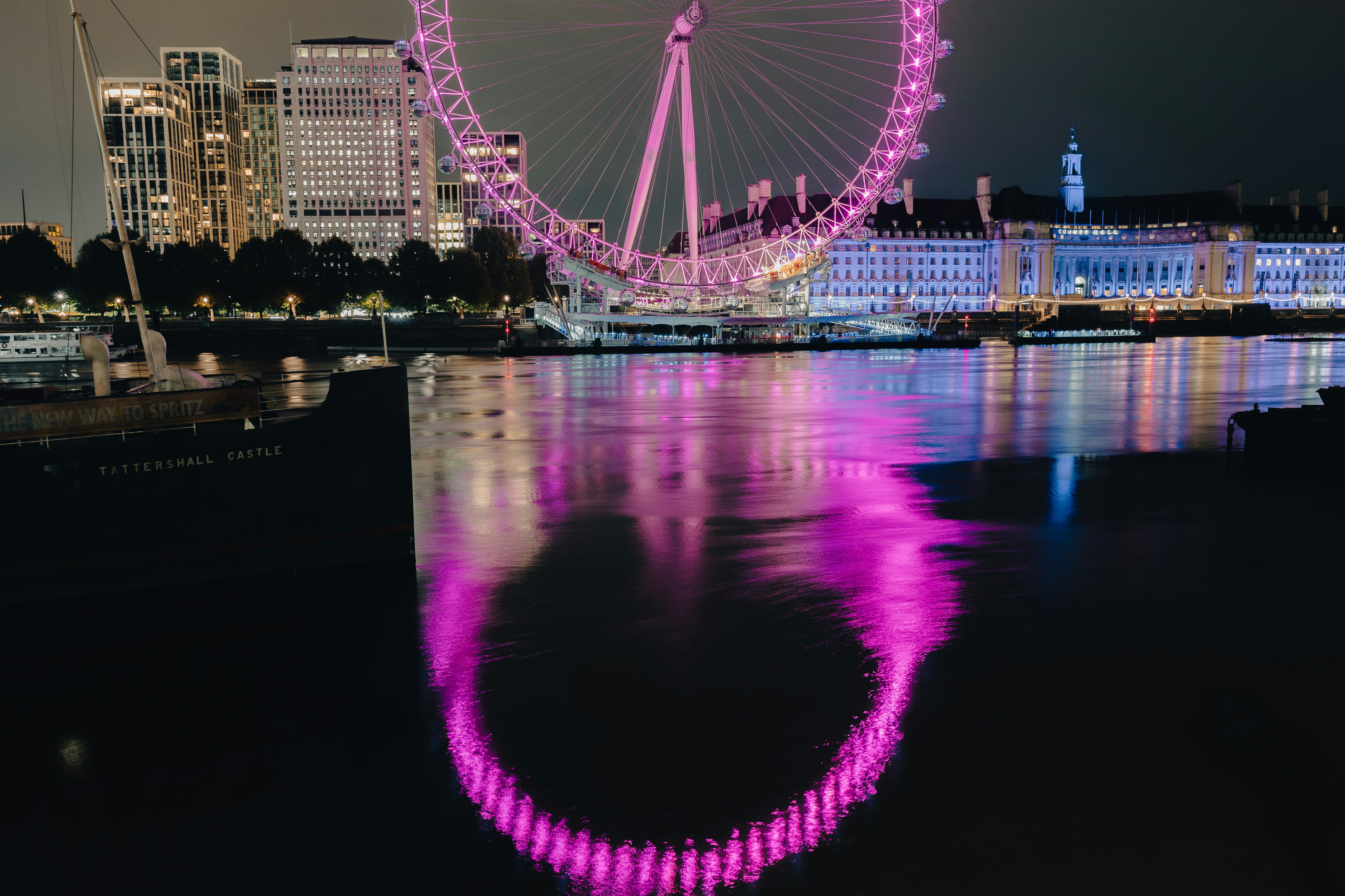 Pink Neon Halo: The London Eye's Thames Reflection