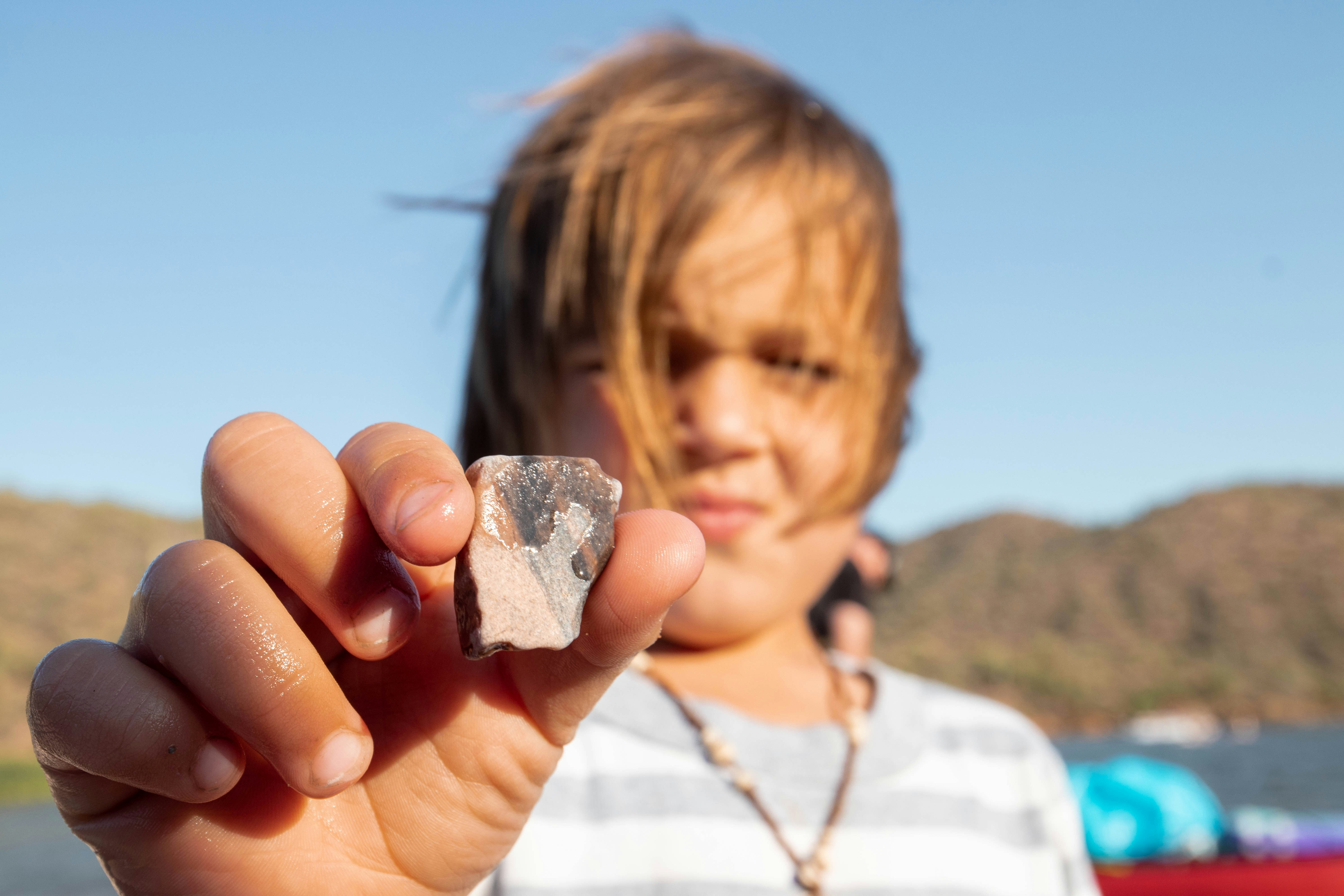 Pebble in Focus: A Handheld Moment by the Water