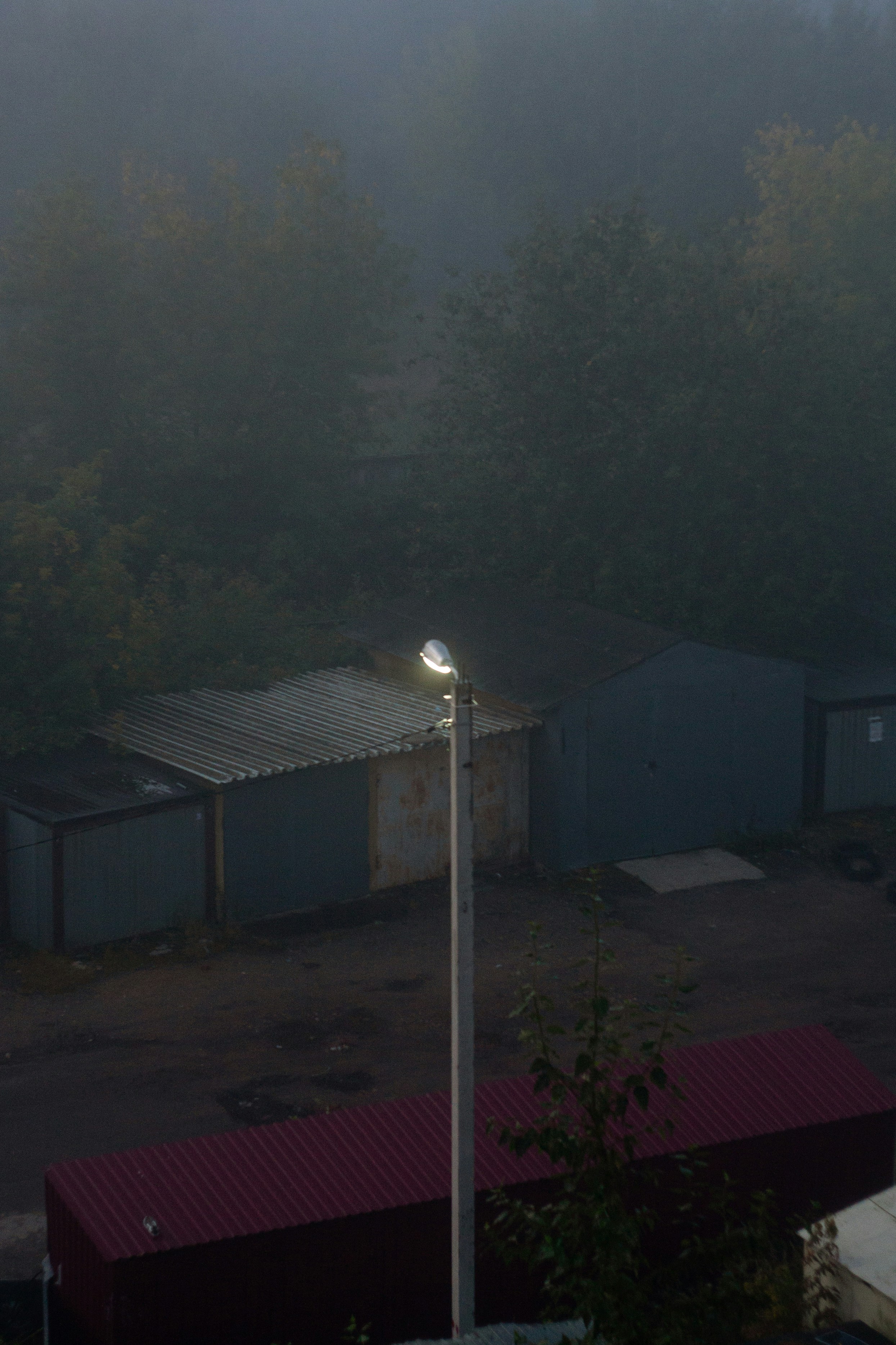 a street light and buildings with trees in the background