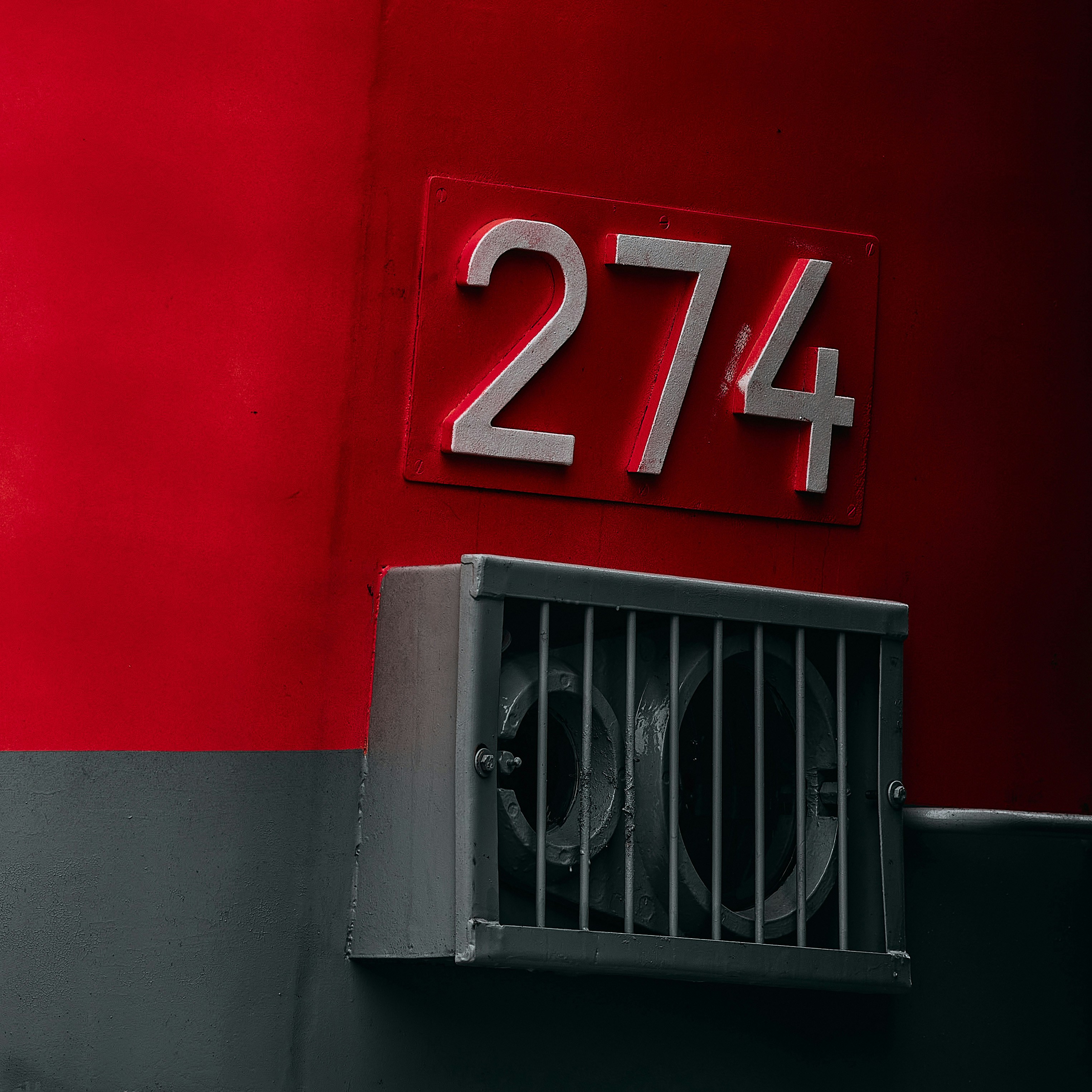 Close-up of a train's number '274' against a red and gray background.