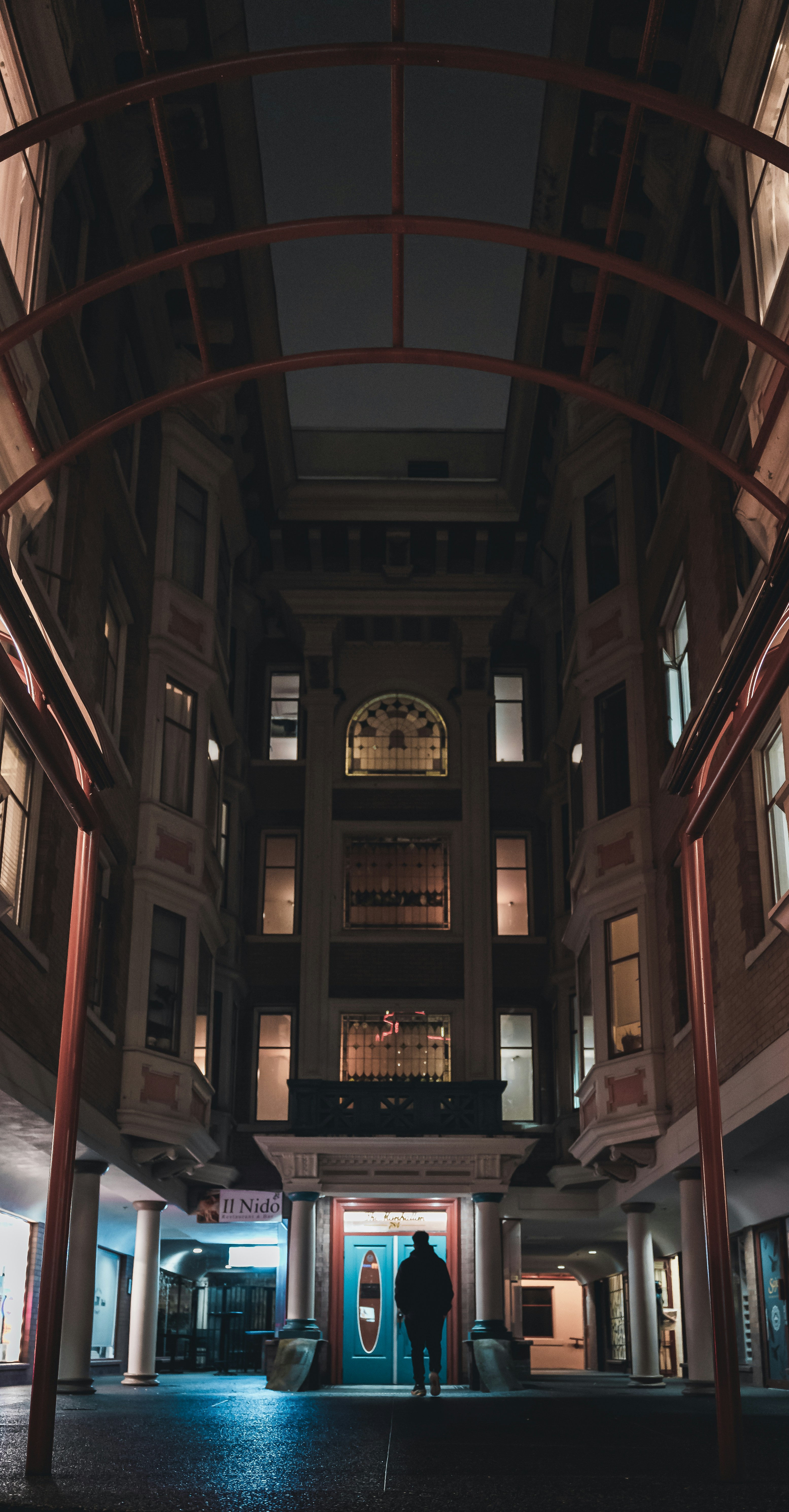 A person walking under a large arched roof photo – Free Person Image on ...