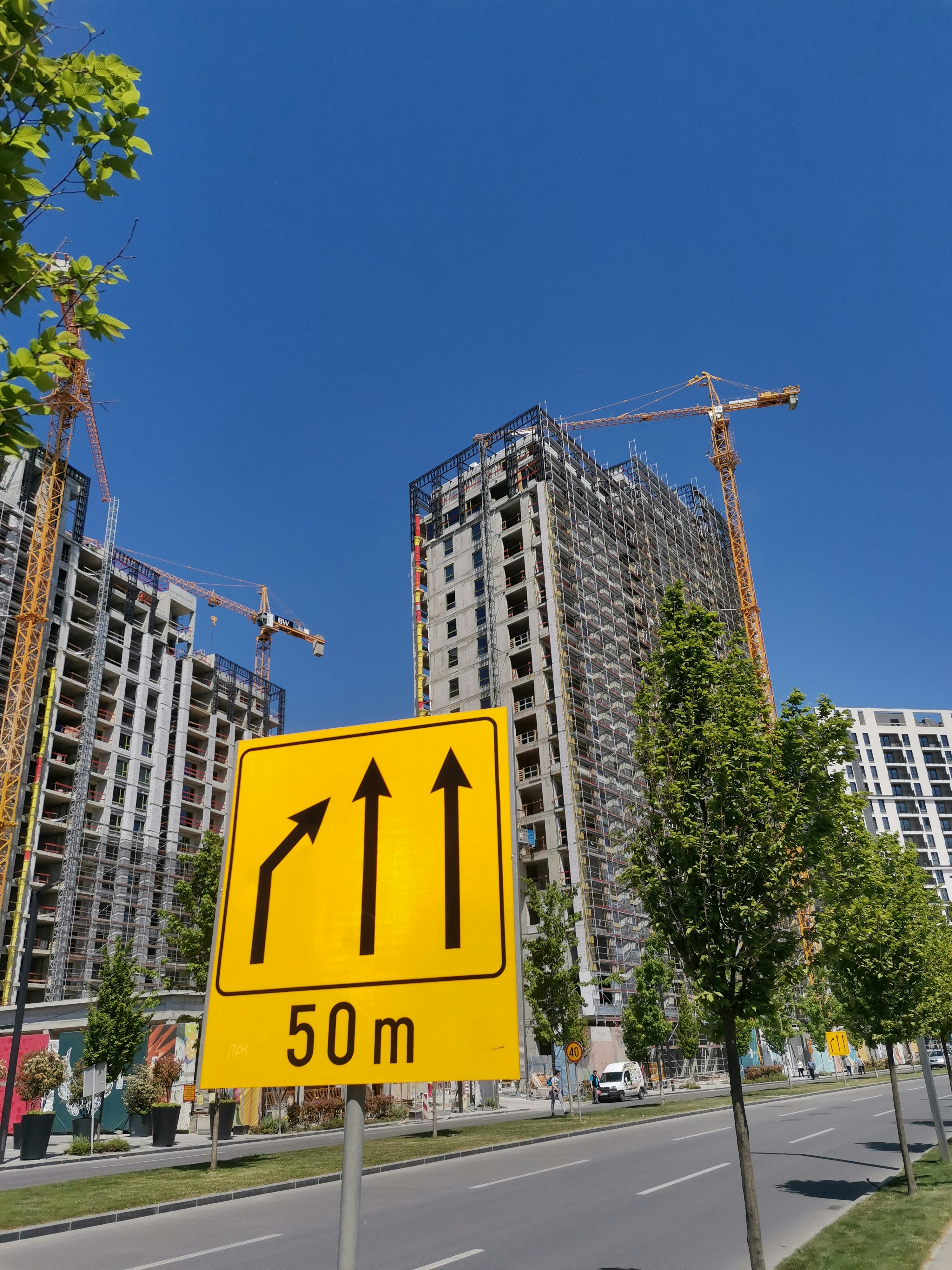 Cranes and Crossroads: A Growing Skyline Framed by a Bold Sign
