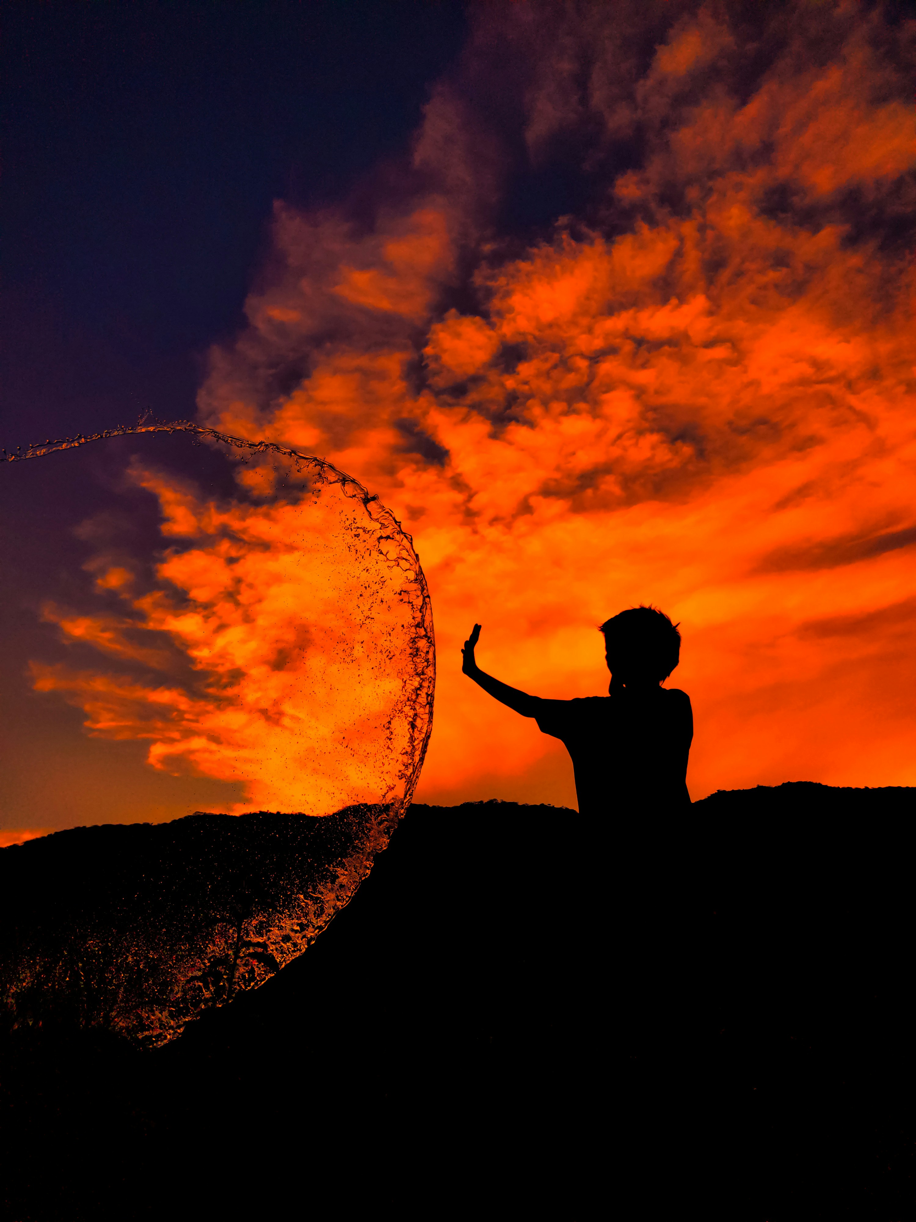Ember Arc at Dusk: Silhouette and Water Ring Against a Fiery Horizon