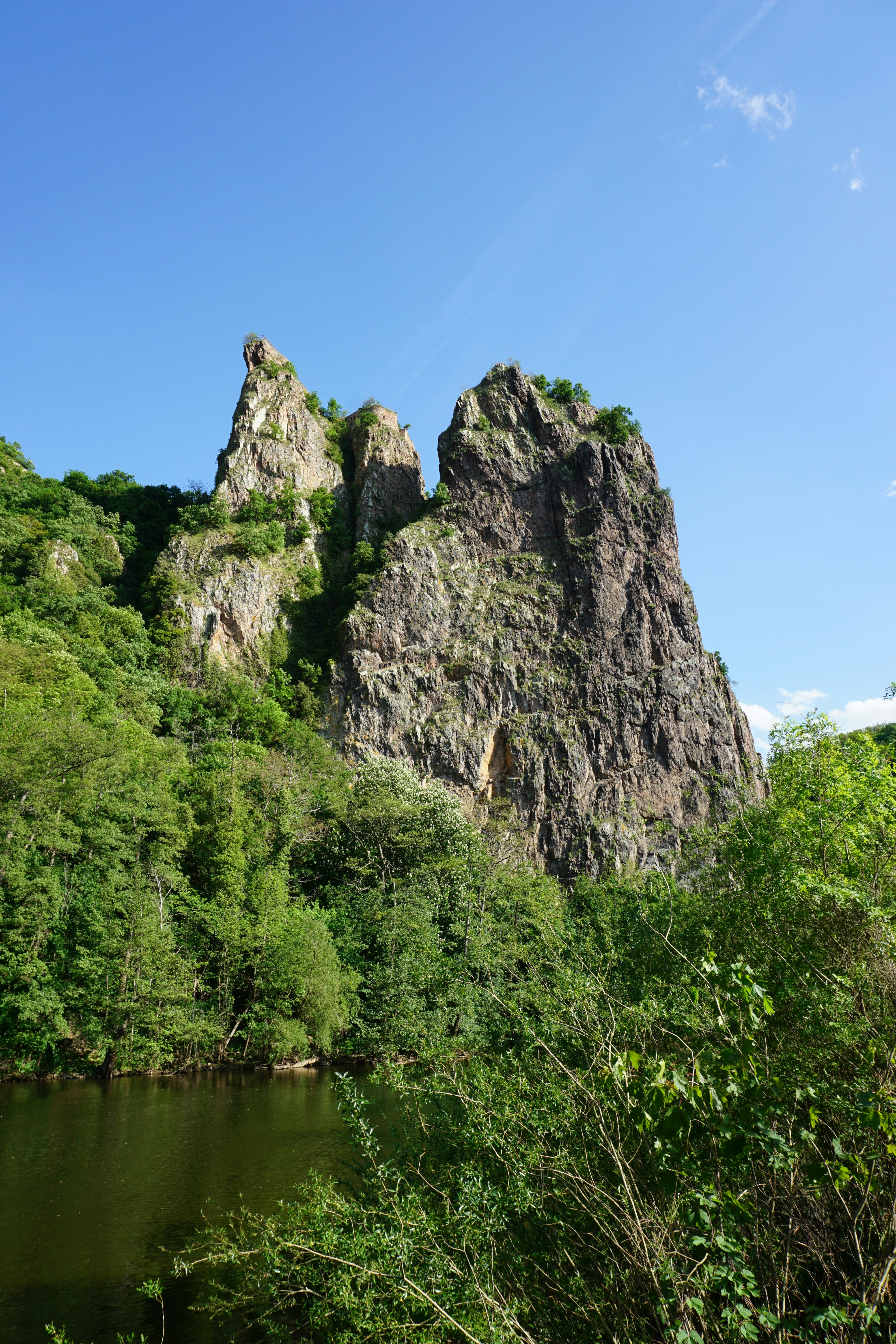 Une falaise rocheuse avec des arbres et de l’eau en contrebas photo ...