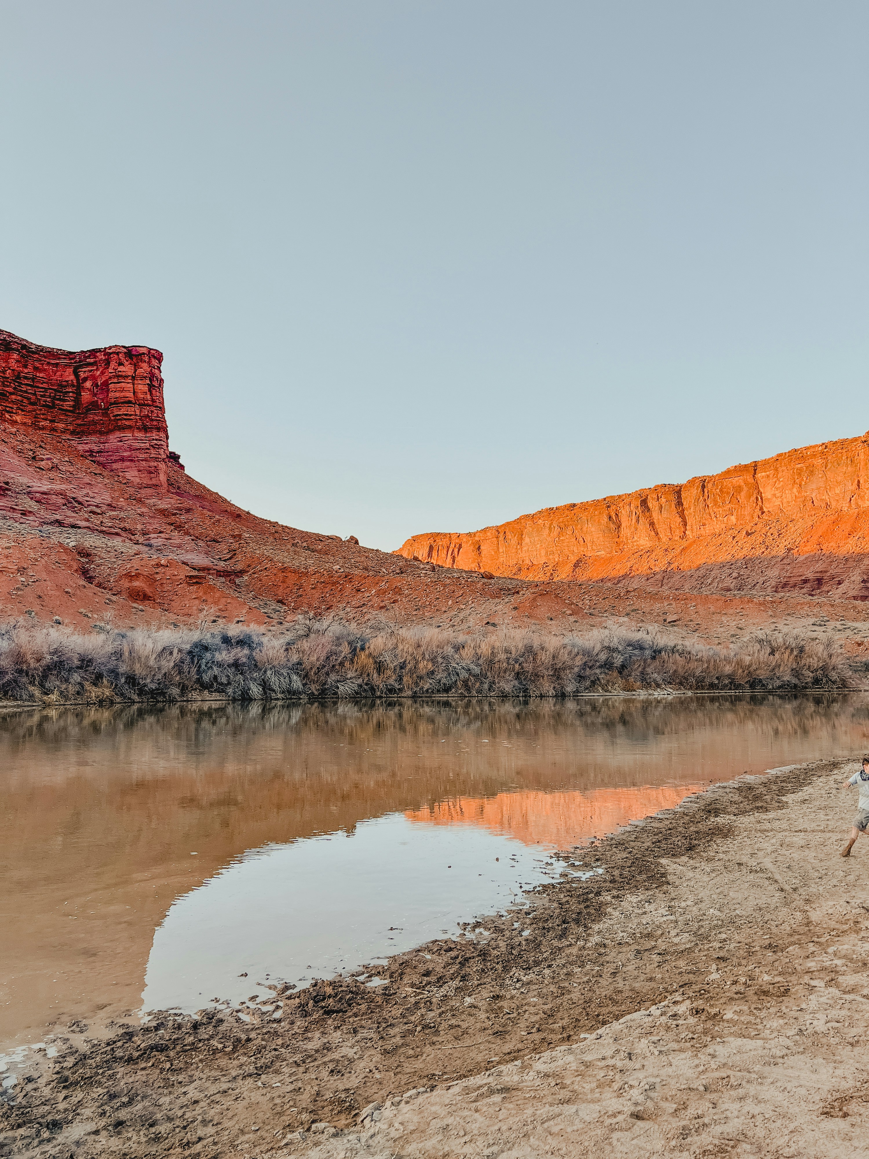 a body of water with a rocky cliff in the background