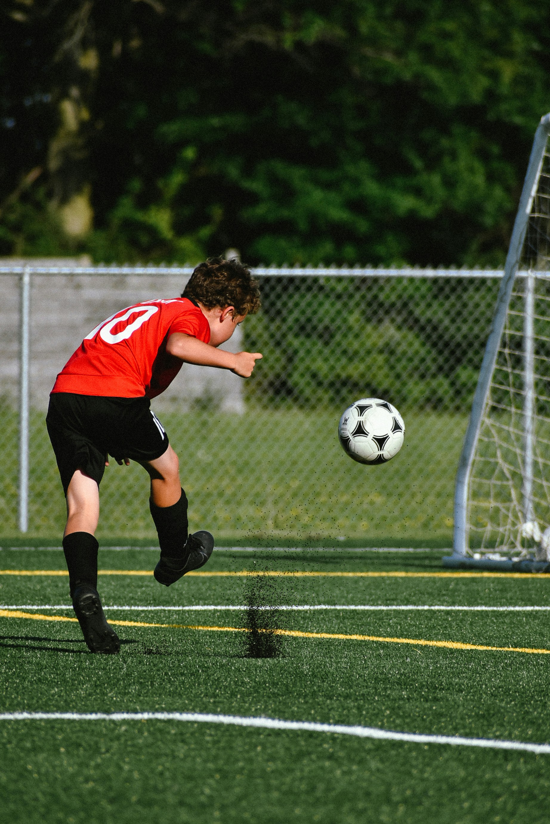 A boy kicking a football ball photo – Free Human Image on Unsplash