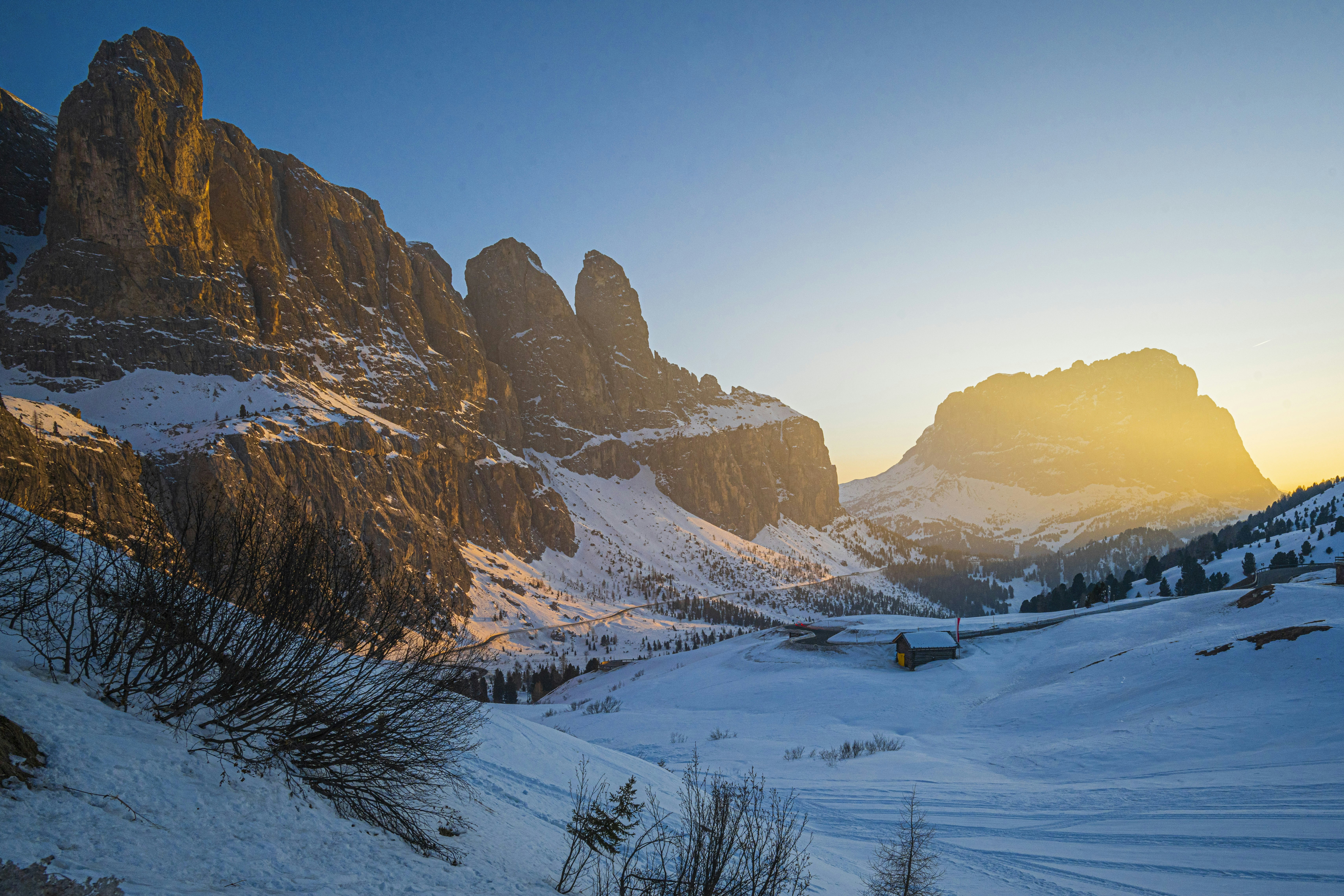 Snow-covered mountains bathed in warm sunlight during sunset.