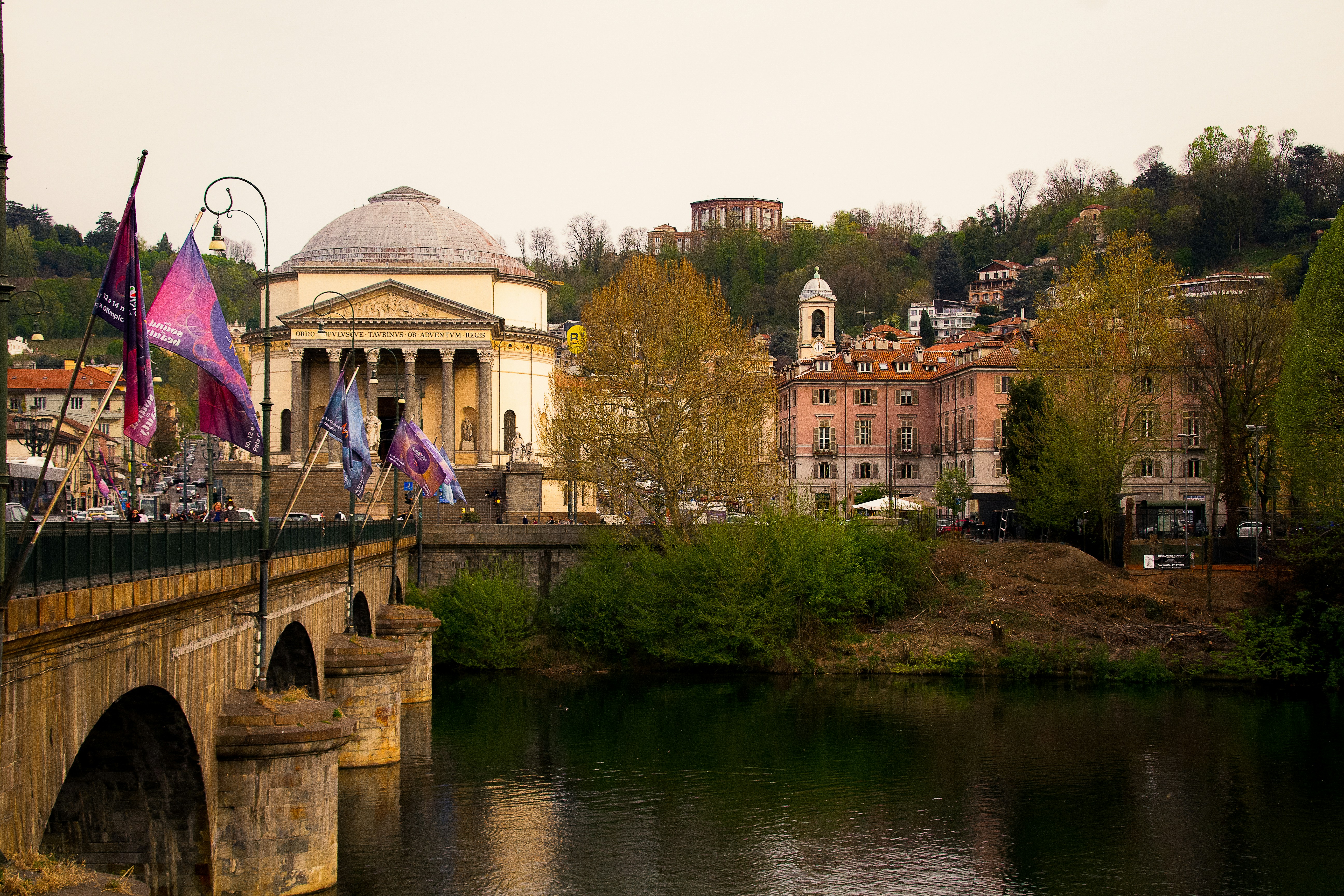A Tuscan-style riverside promenade bridging a timeless city