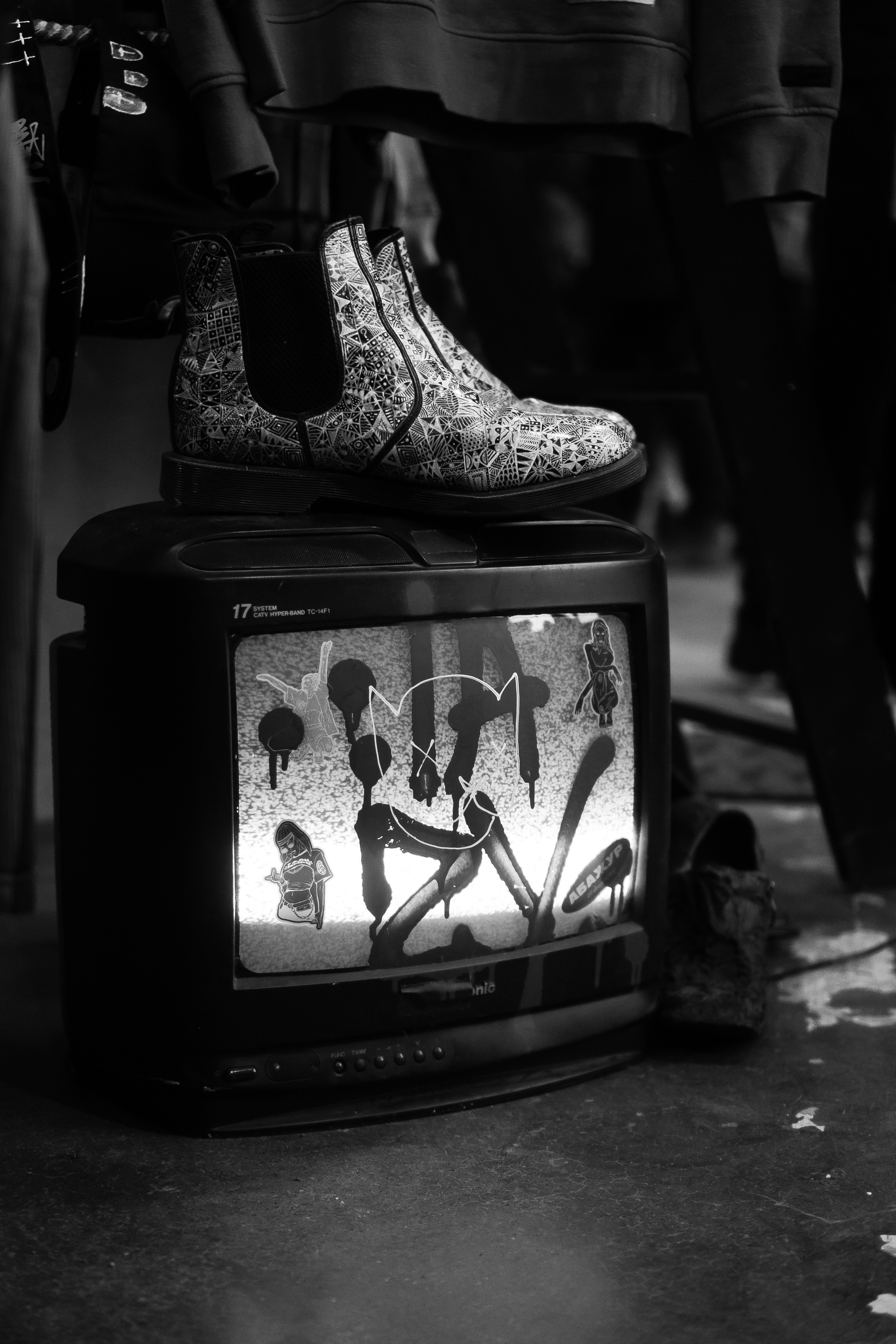 Boot on a Graffiti-Touched TV: A Quiet Monochrome Street Scene