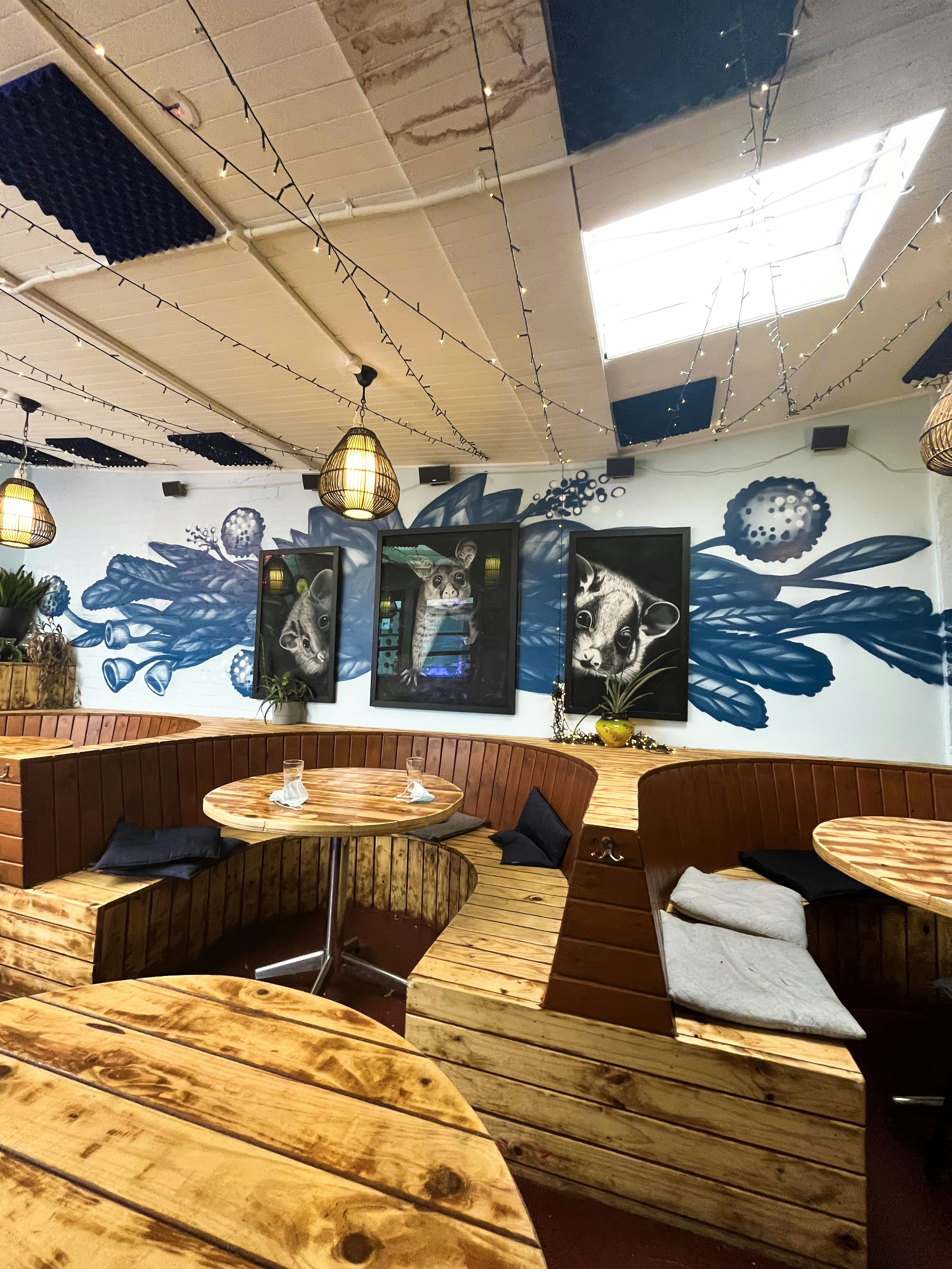 Bear Portraits Under a Blue Garden: A Cozy Café Booth Scene