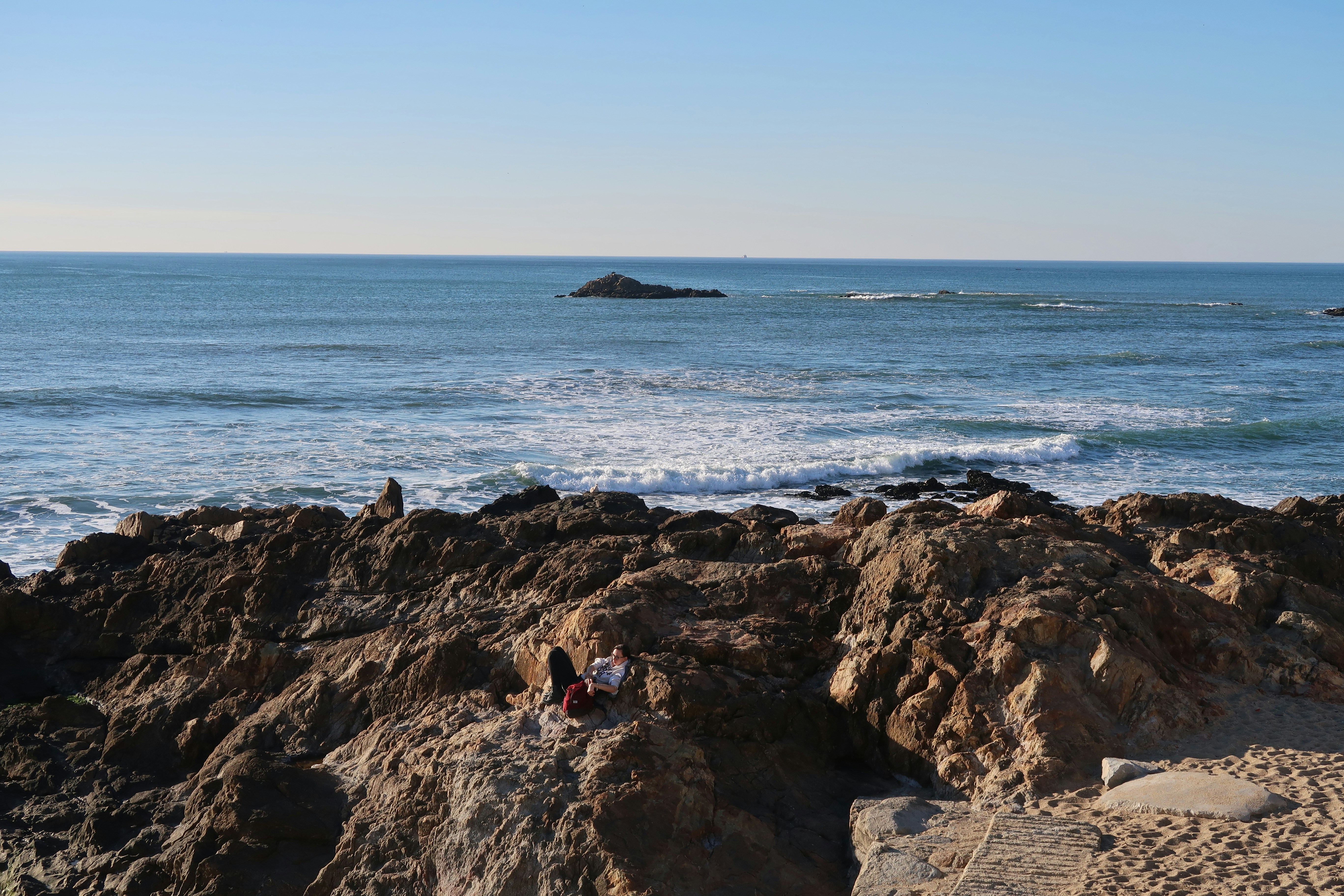 a rocky beach with a body of water in the background