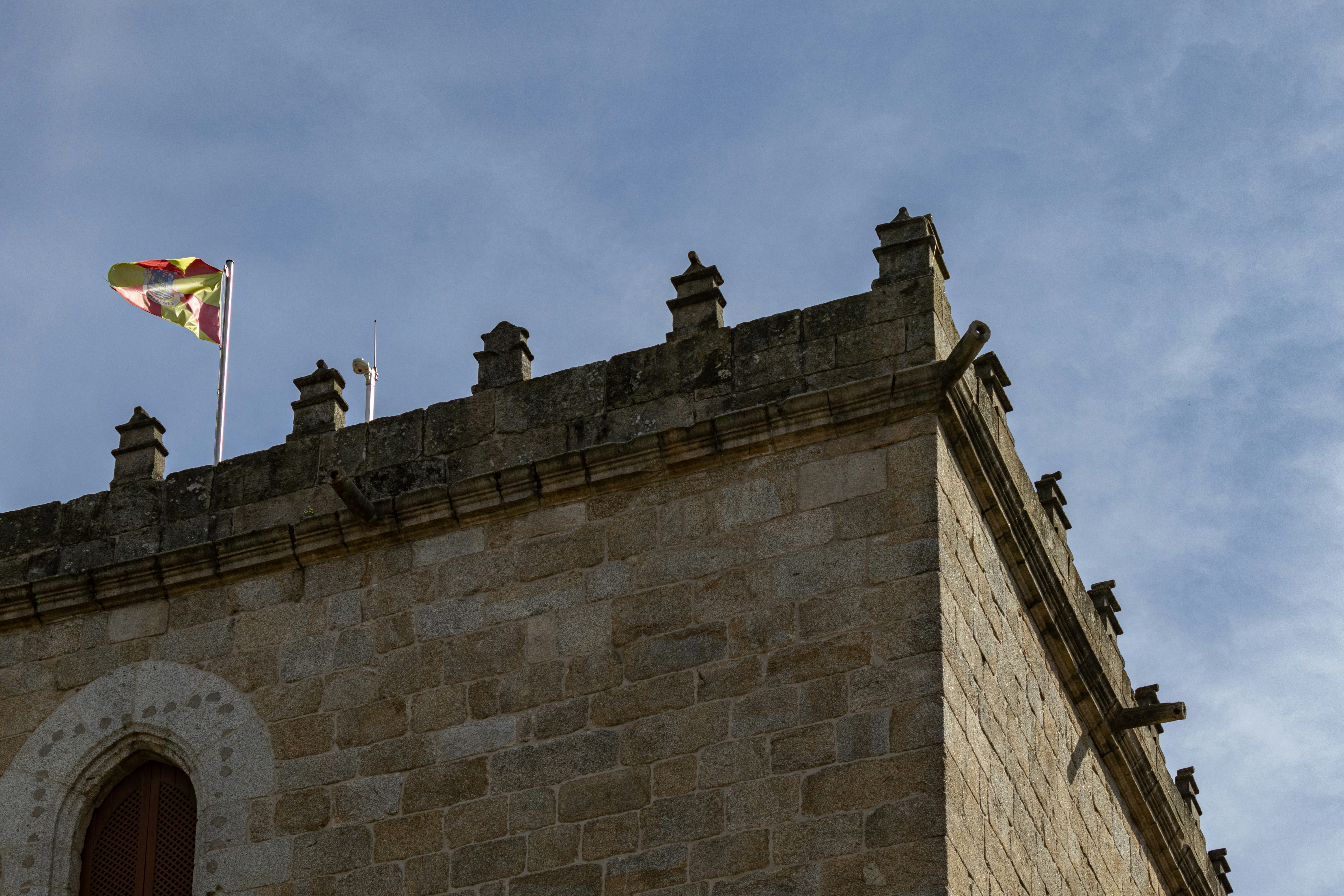 Flag on the Crest: A Sunlit Bastion Against a Bright Sky