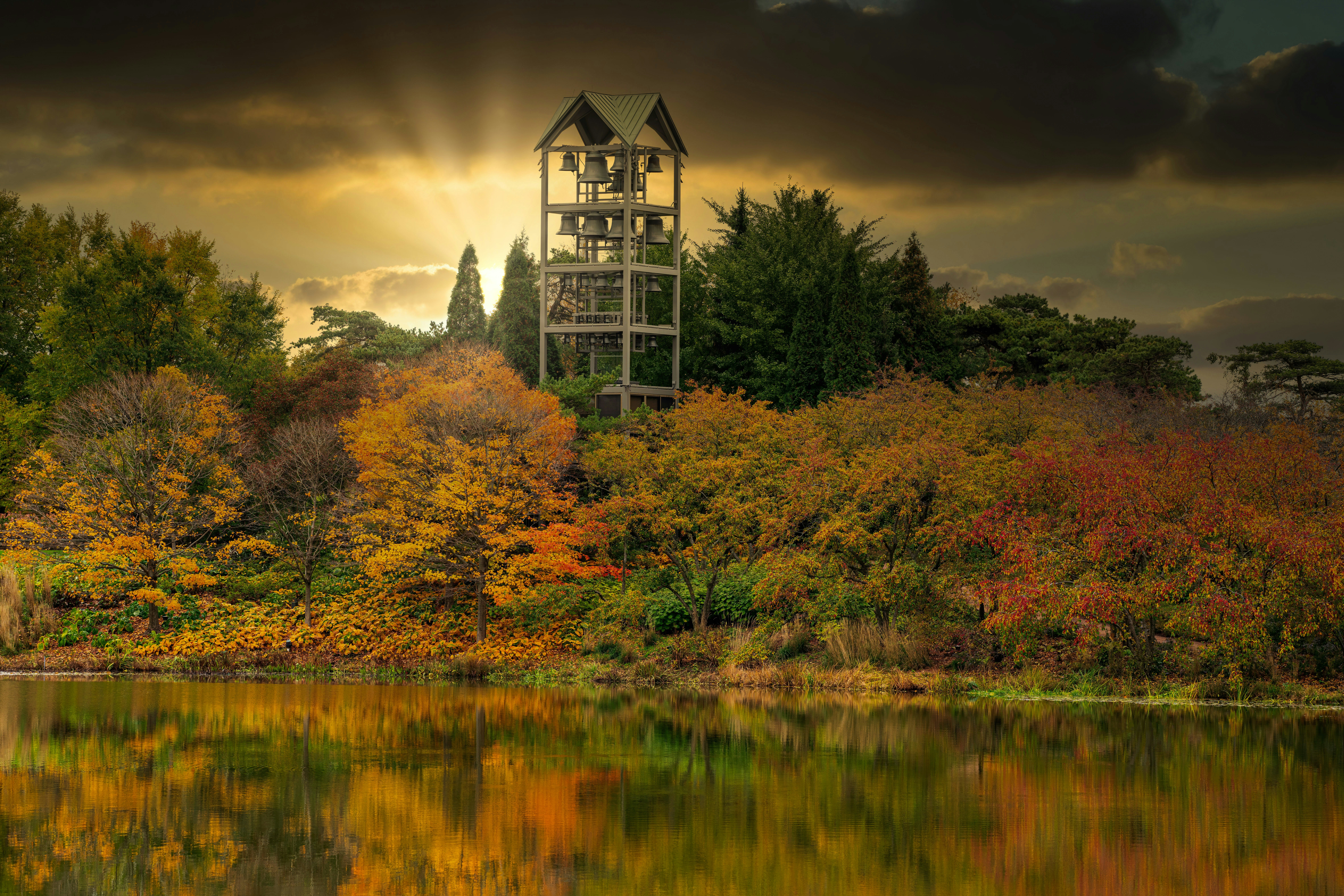 a building with a tower surrounded by trees and water