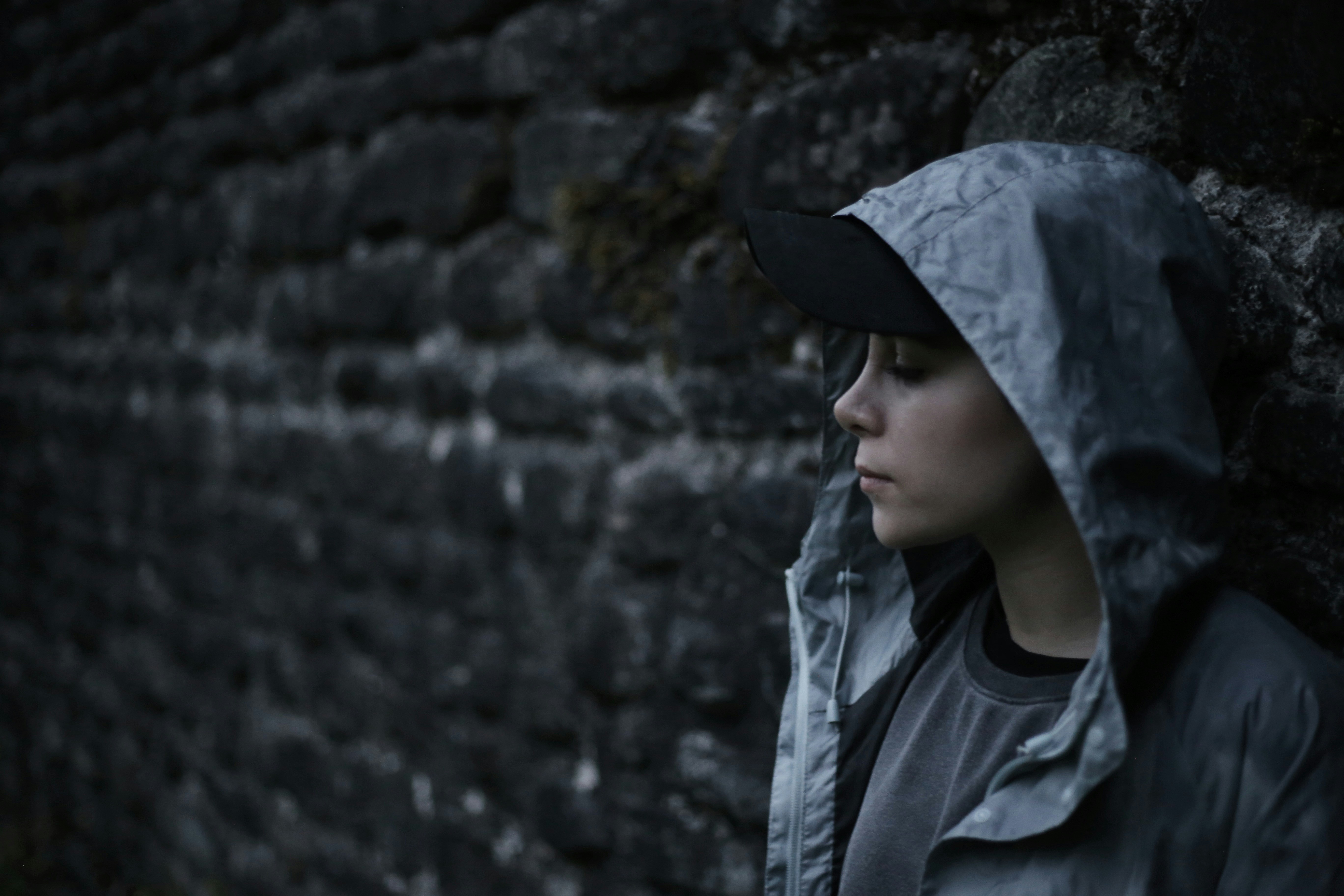 Edge of Silence: A Hooded Portrait by Weathered Stone