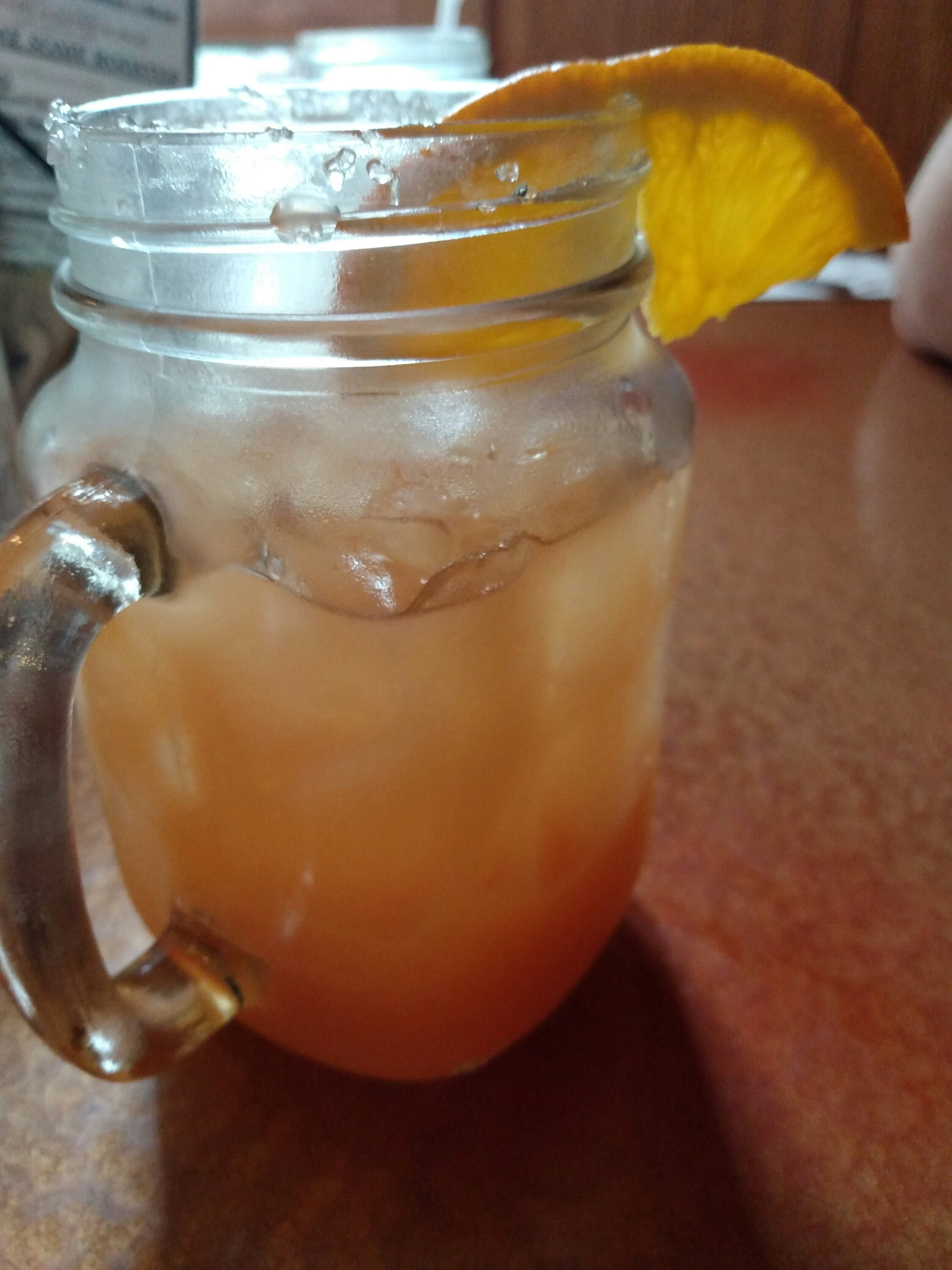 A mason jar with a lemon wedge on top of it photo – Free Brown Image on ...