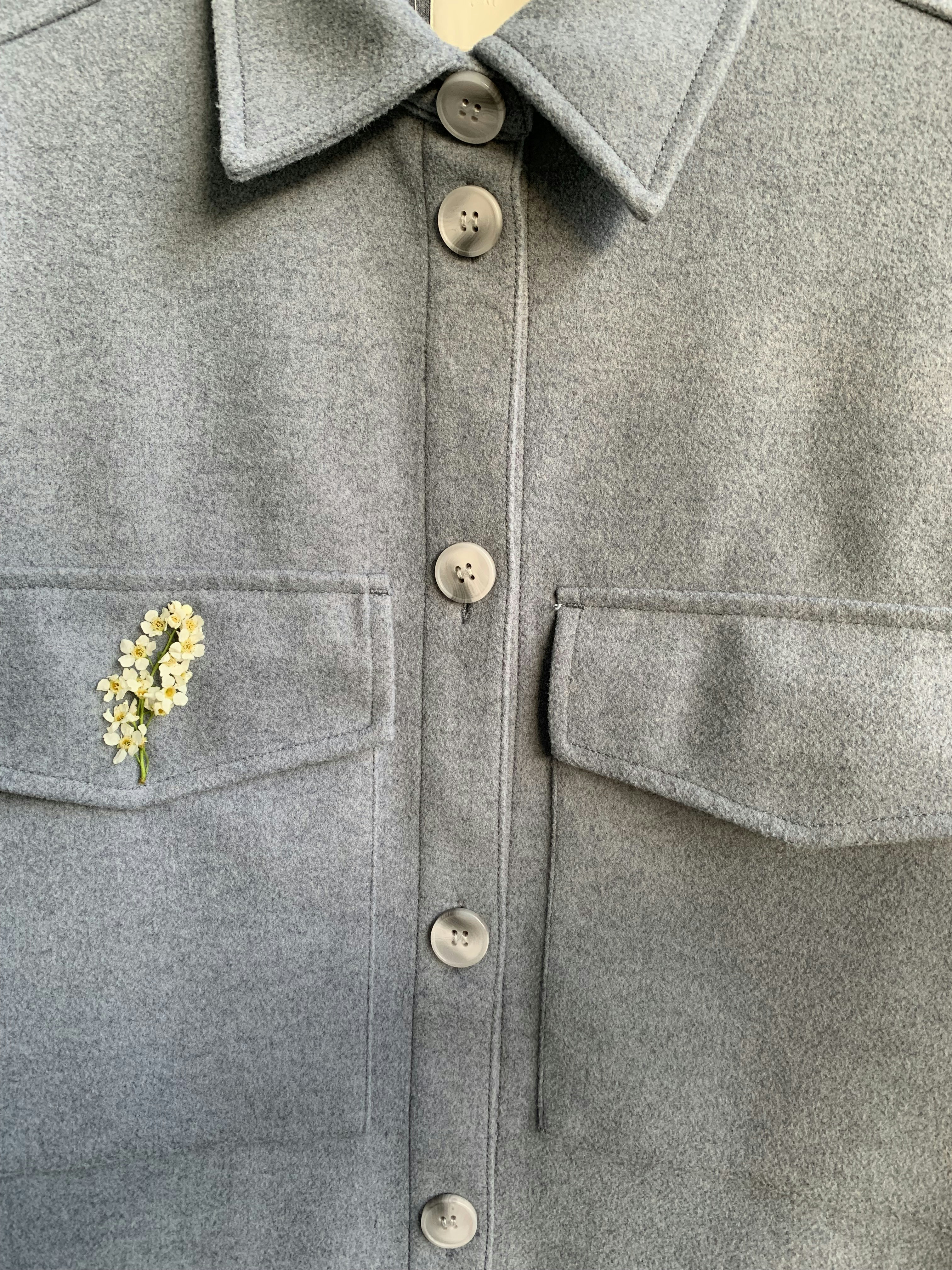 a close up of a shirt with a flower on it