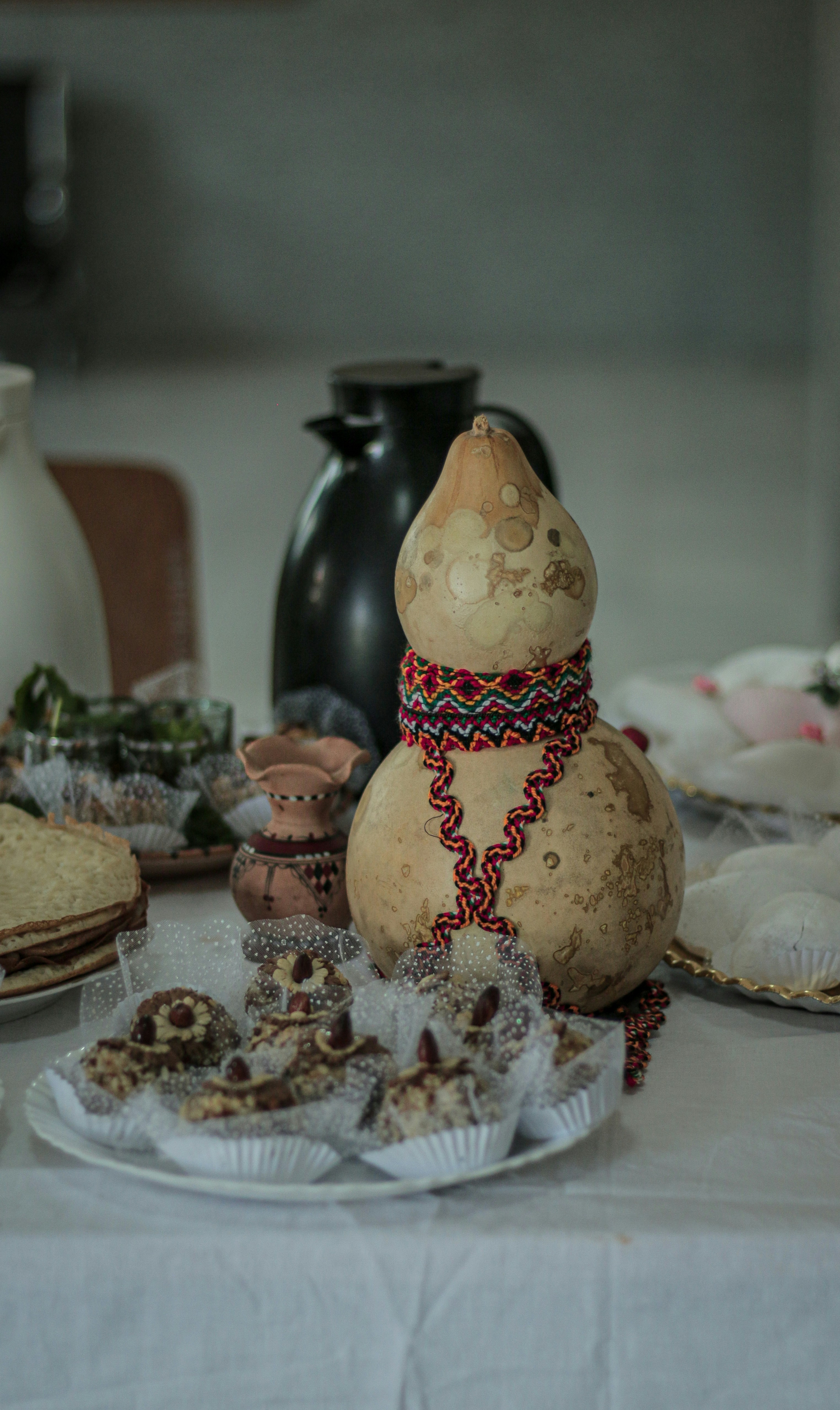Beaded Gourd Centerpiece: A Rustic Tabletop Still-Life with Pastries and Teapot