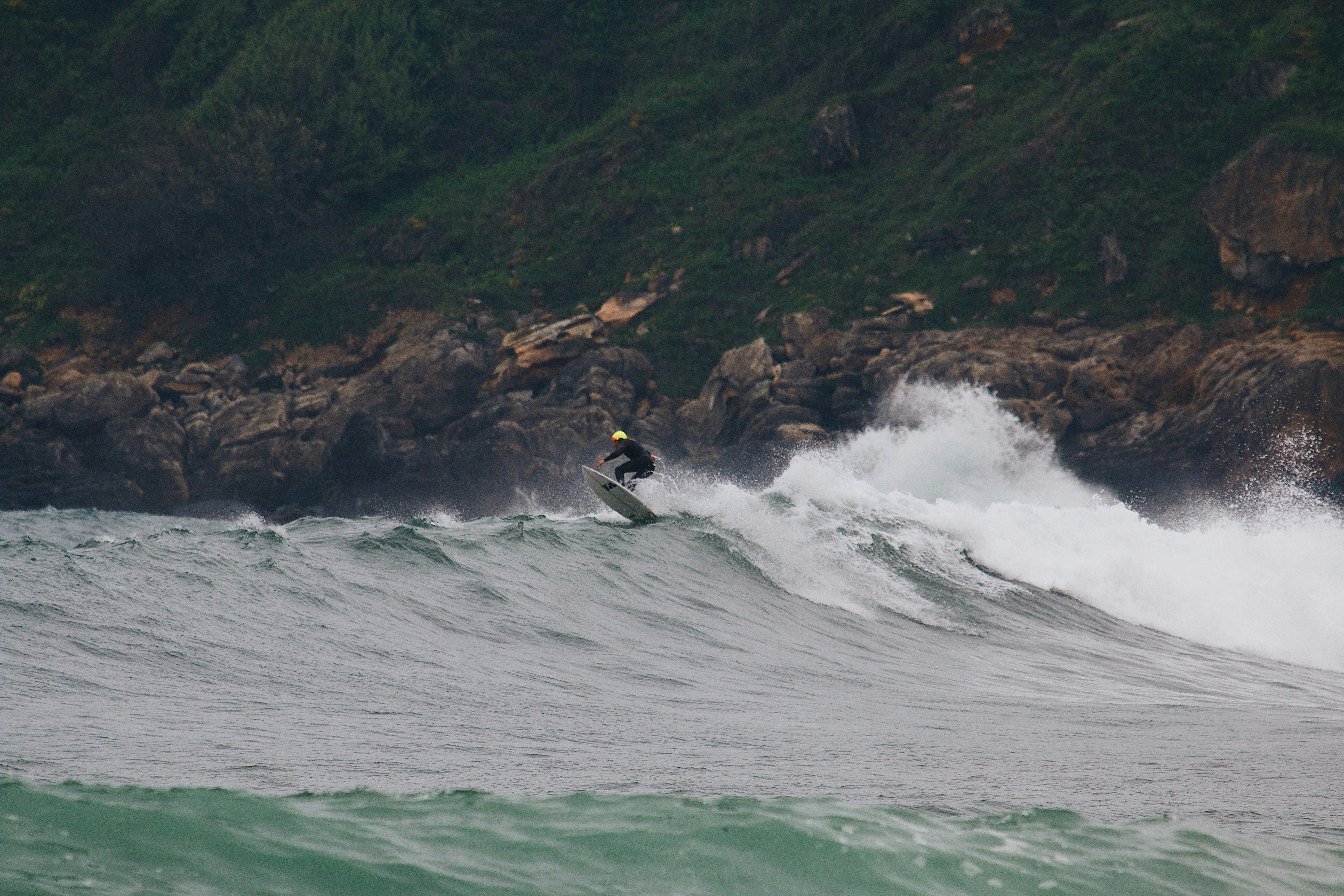 Un homme chevauchant une vague sur une planche de surf photo – Photo ...