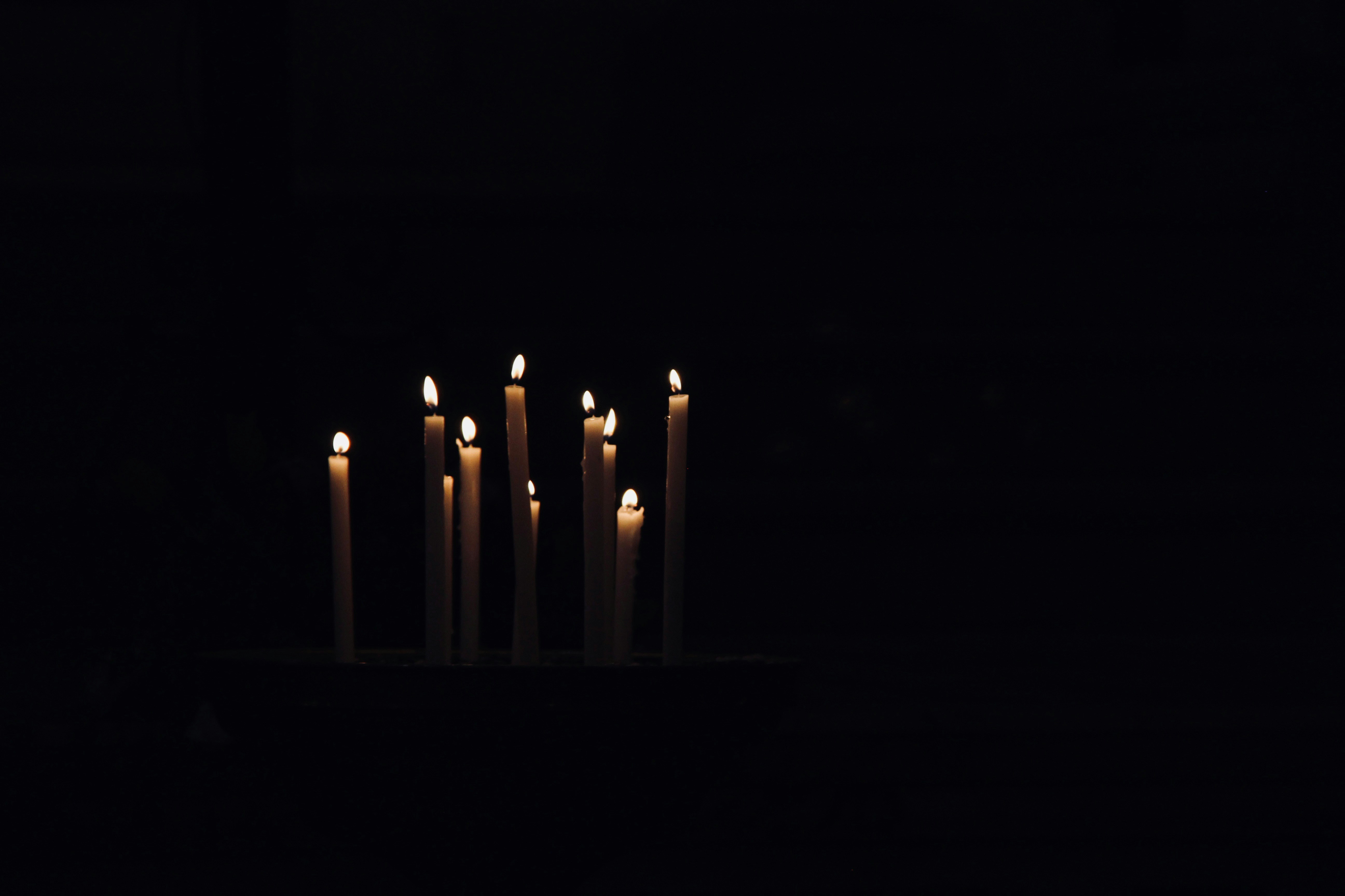 A collection of lit candles illuminating a dark space, creating a serene and contemplative atmosphere.