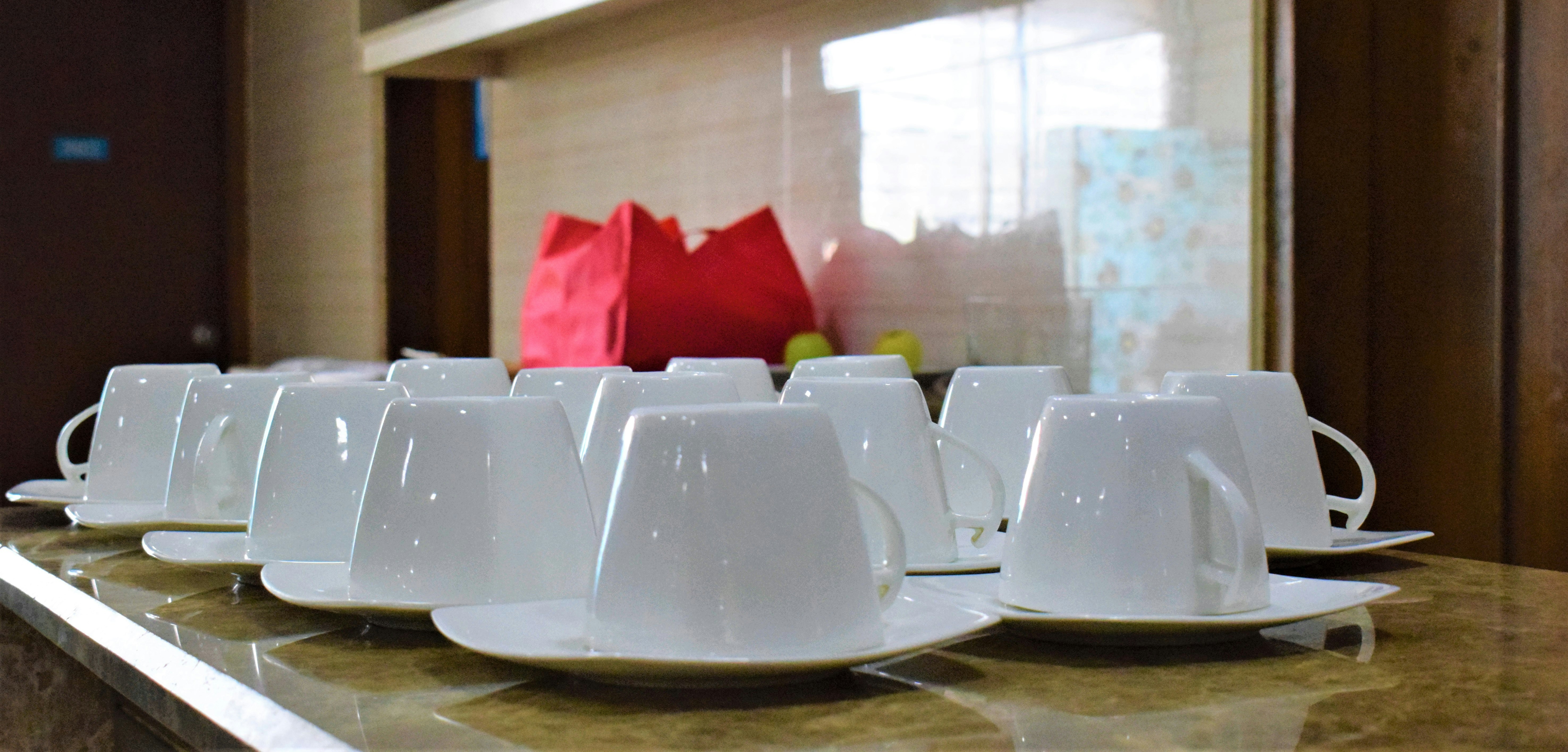Rhythmic Rows of White Cups on a Marble Café Table