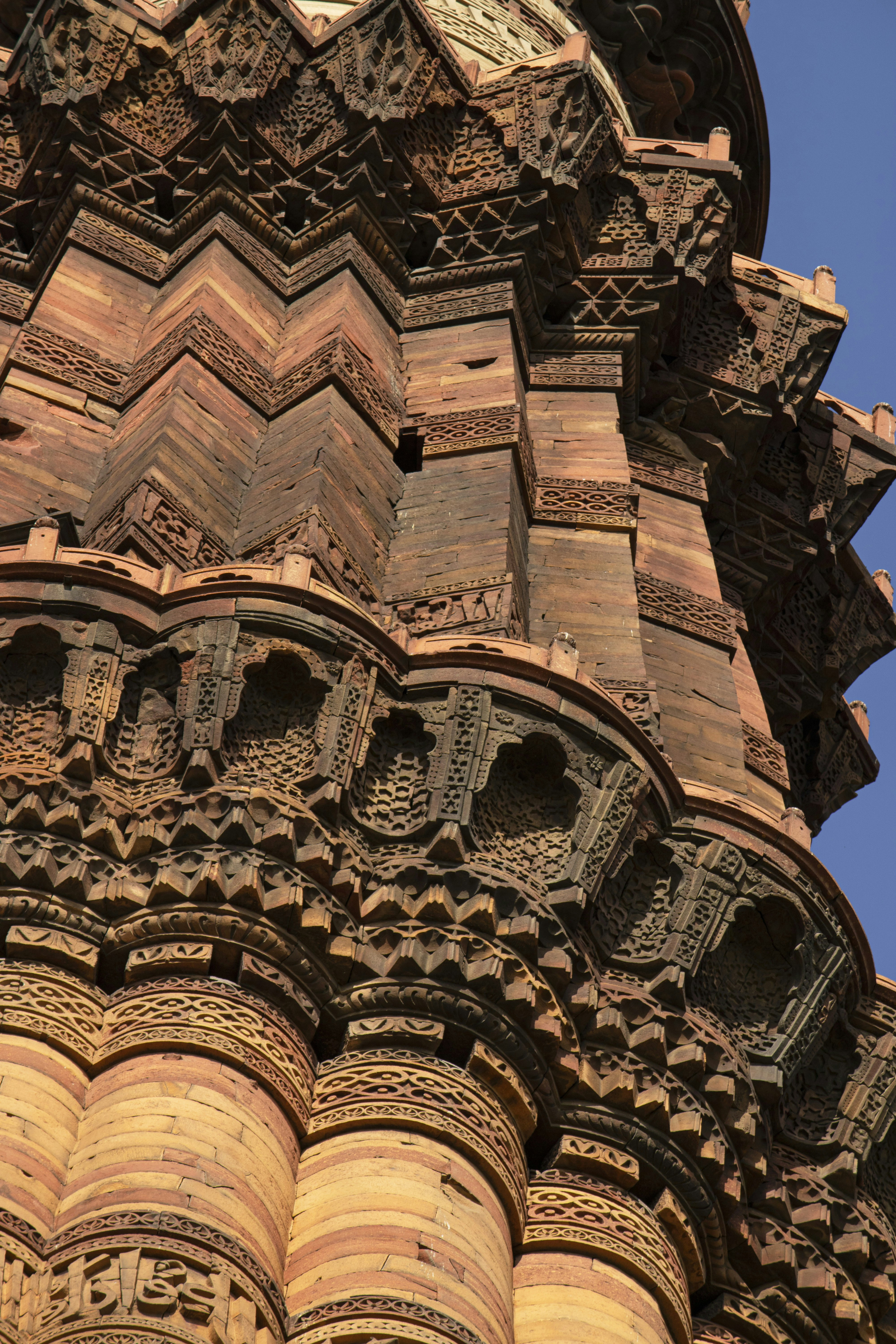 Rust-Red Shikhara: Timeworn Stone Carvings in Vertical Tiers