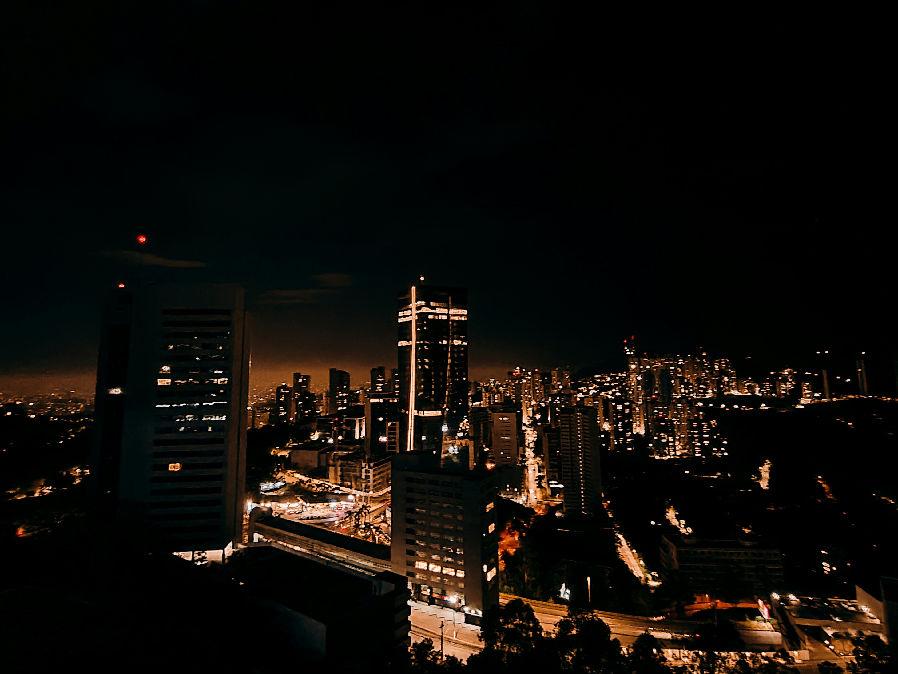 Vibrant city skyline illuminated against the night sky, showcasing modern architecture and bustling streets below.