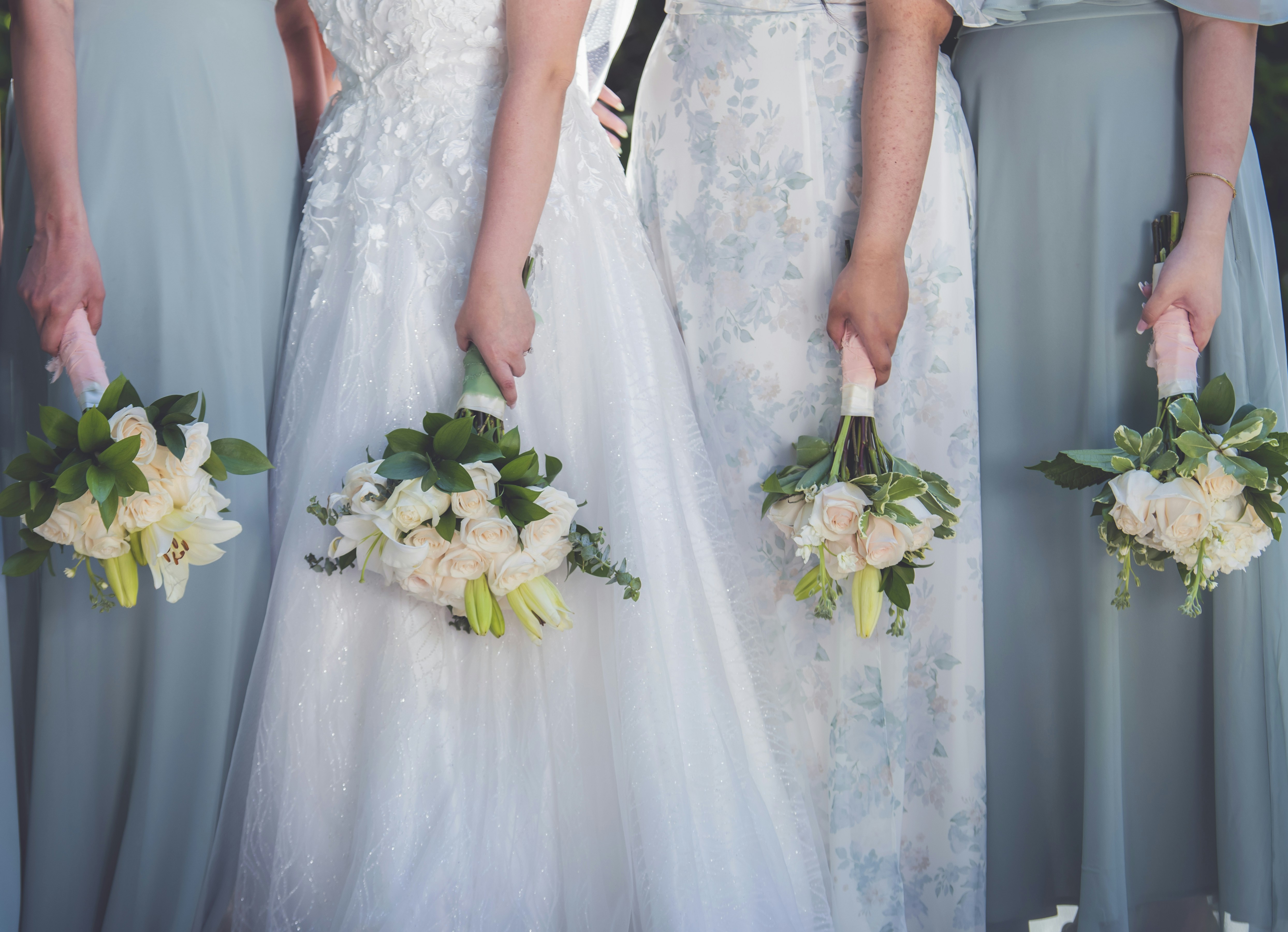 a group of women standing next to each other holding bouquets