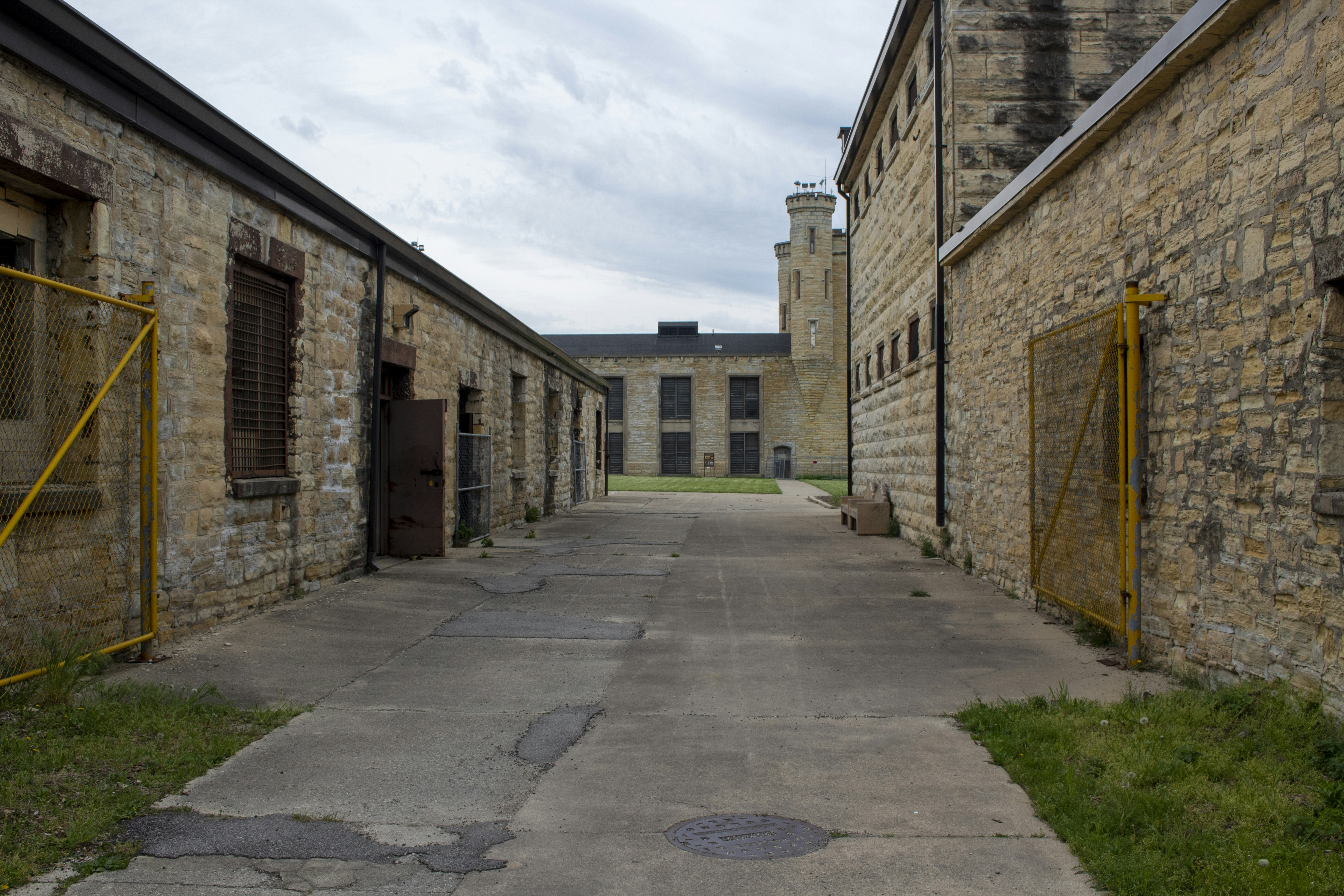An alley way between two buildings with a clock tower in the background ...