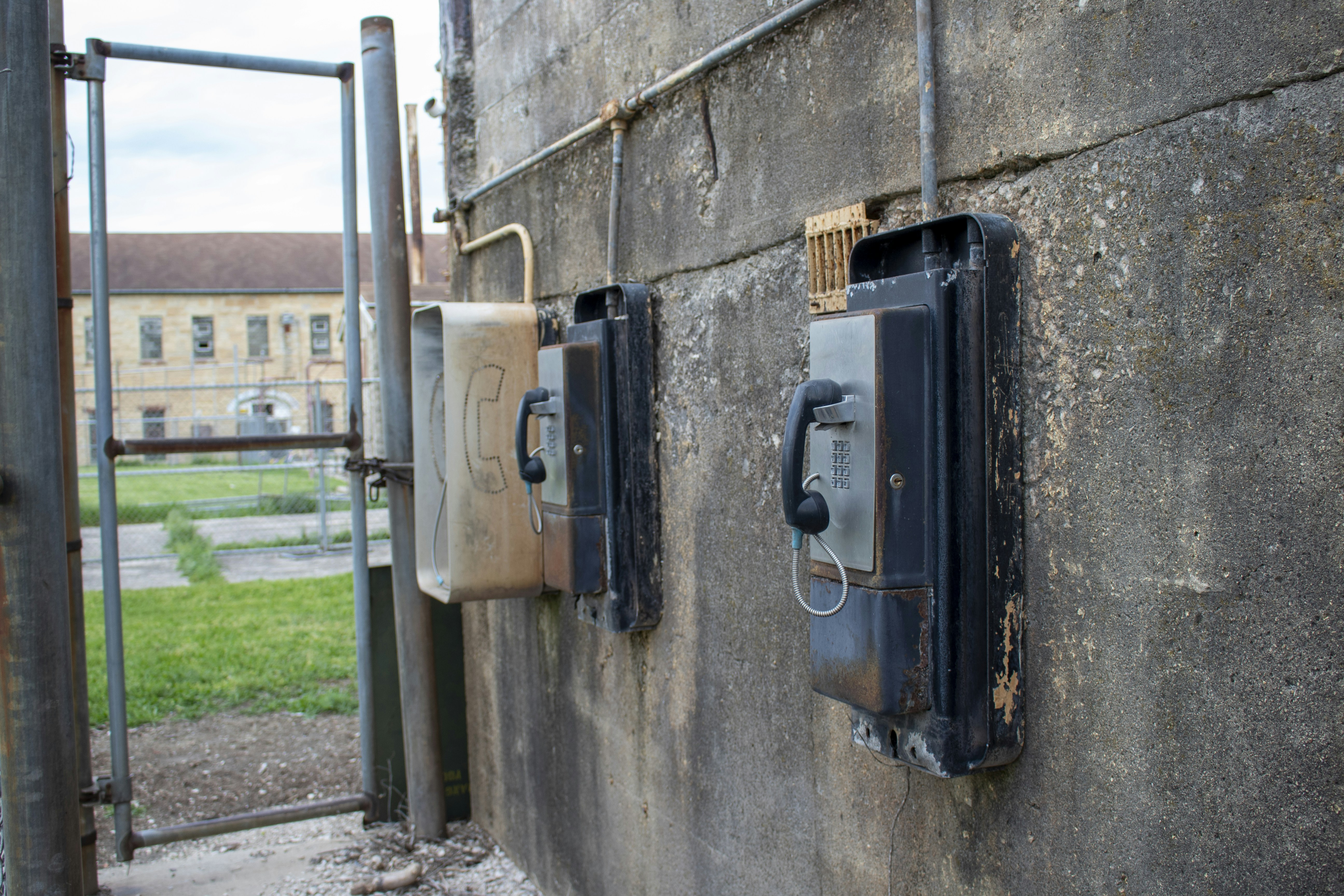 Industrial Conduit Echoes: Weathered Boxes on a Concrete Wall