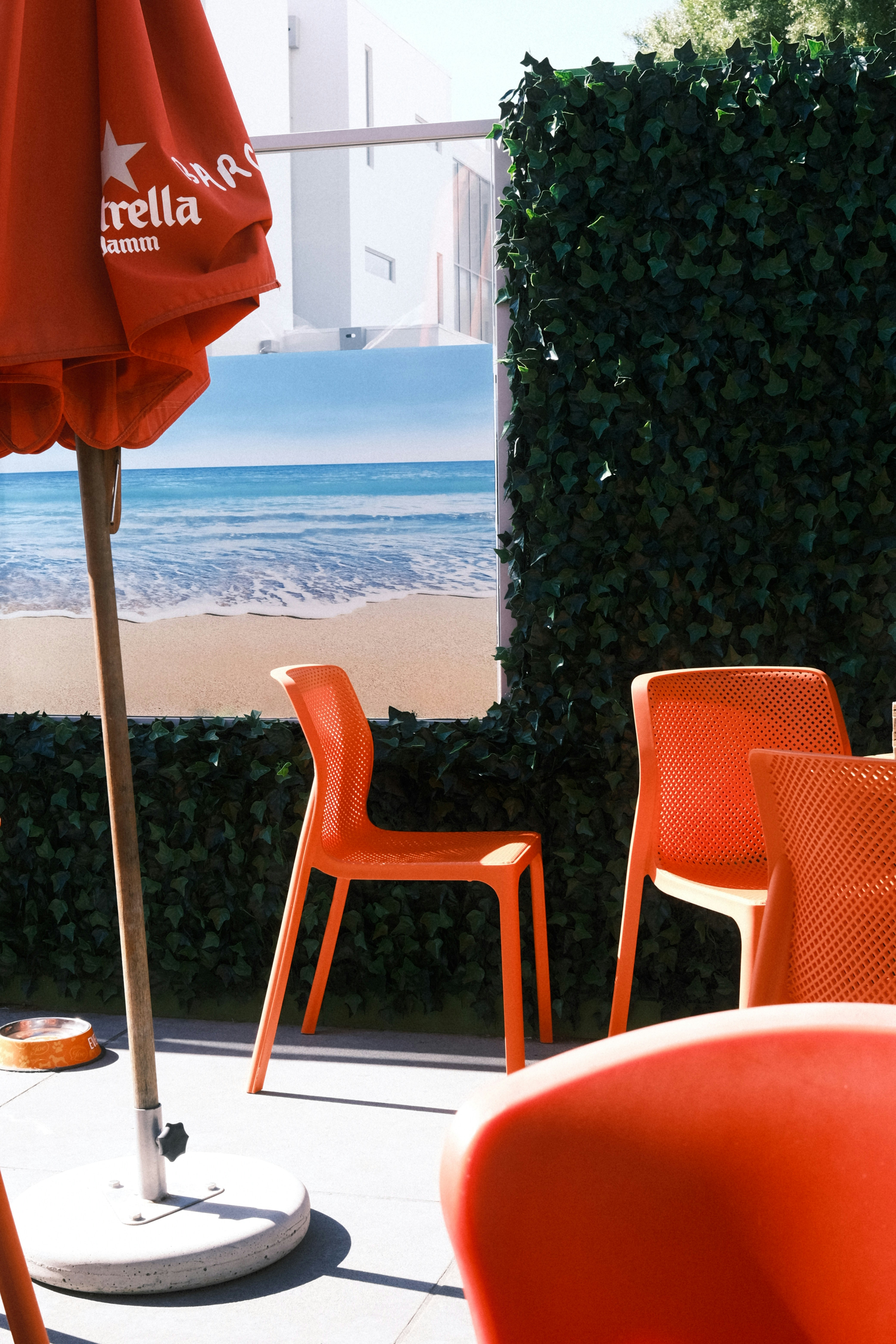 orange chairs and an umbrella on a patio