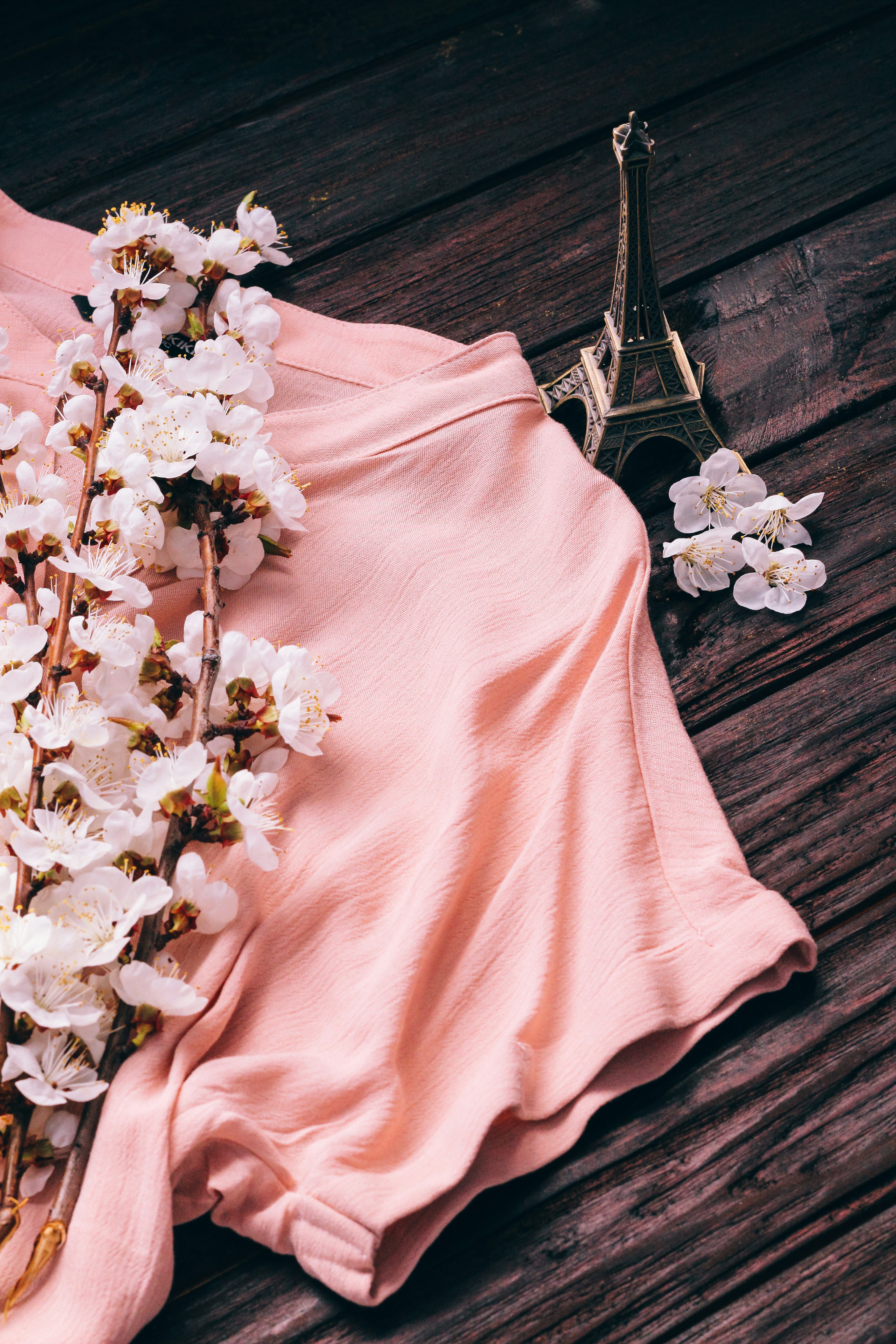 Pink Drapery, White Blossoms, and a Mini Eiffel Tower: A Quiet Still-Life on Dark Wood